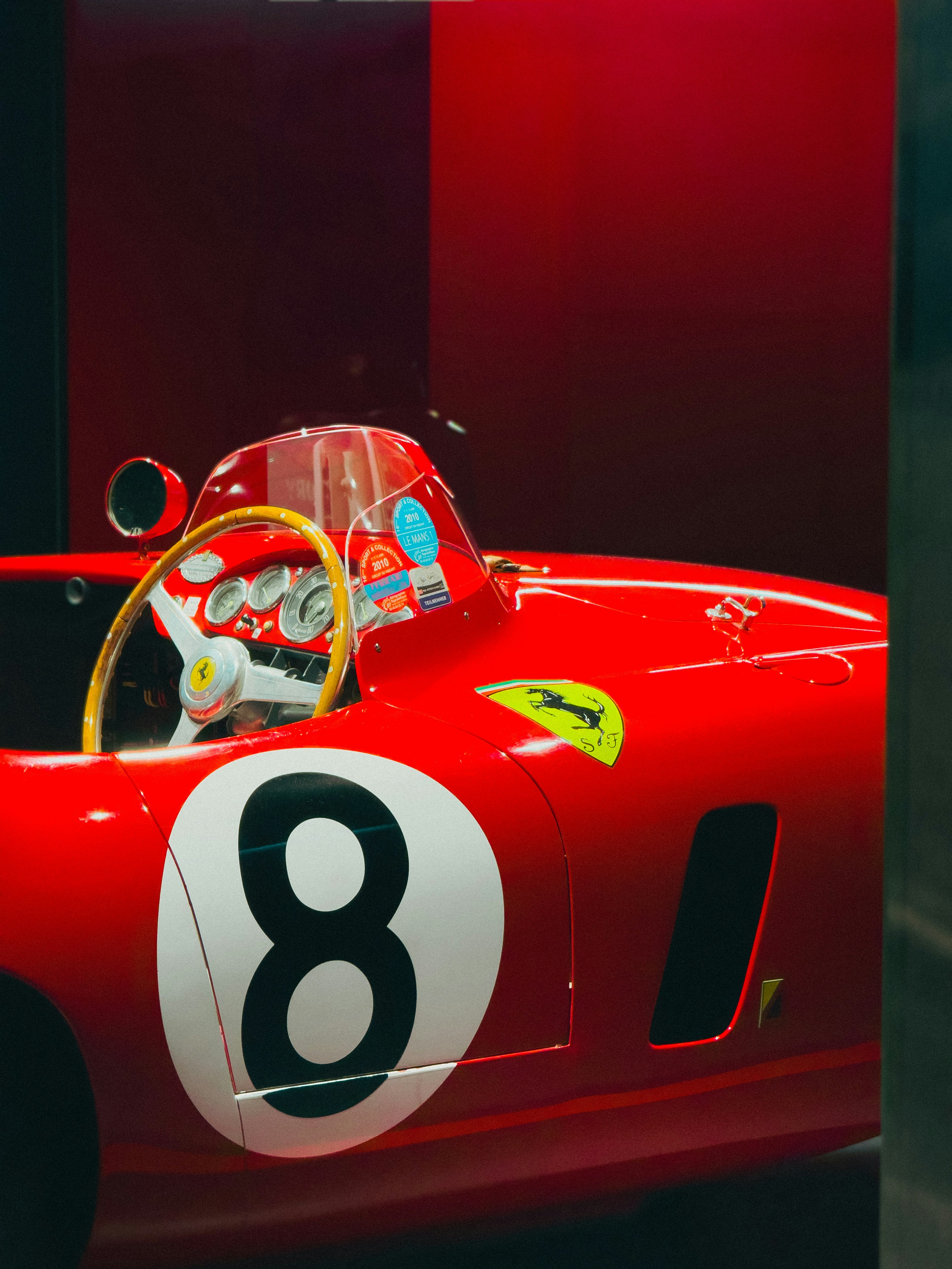 Vintage Ferrari race car with number 8 livery displayed at Museo Ferrari Maranello in Italy. Featuring a yellow steering wheel and polished red body, this car reflects Ferrari’s early racing era and timeless Italian craftsmanship.