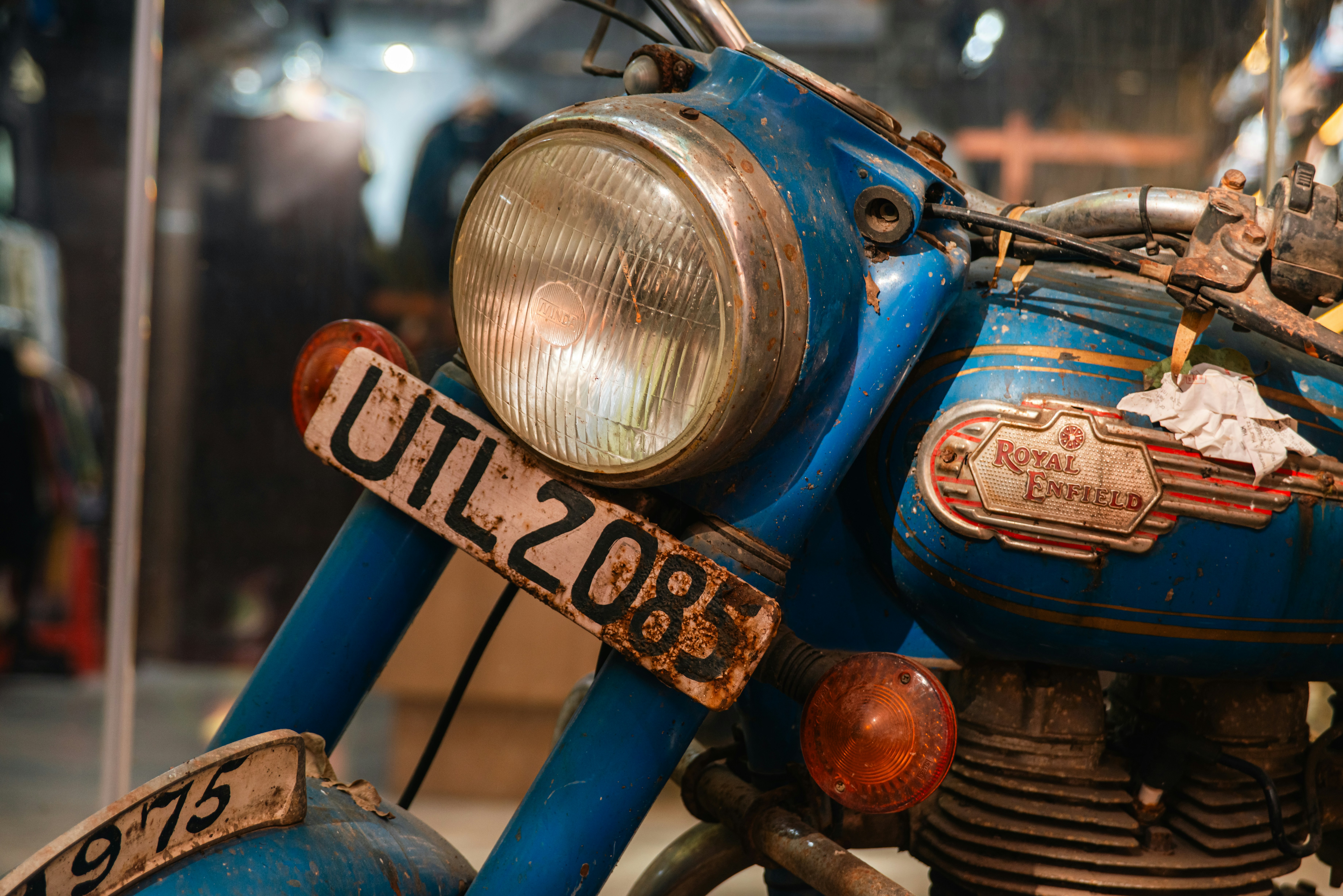 Blue Relic Under Indoor Glow: A Close-Up of a Vintage Royal Enfield