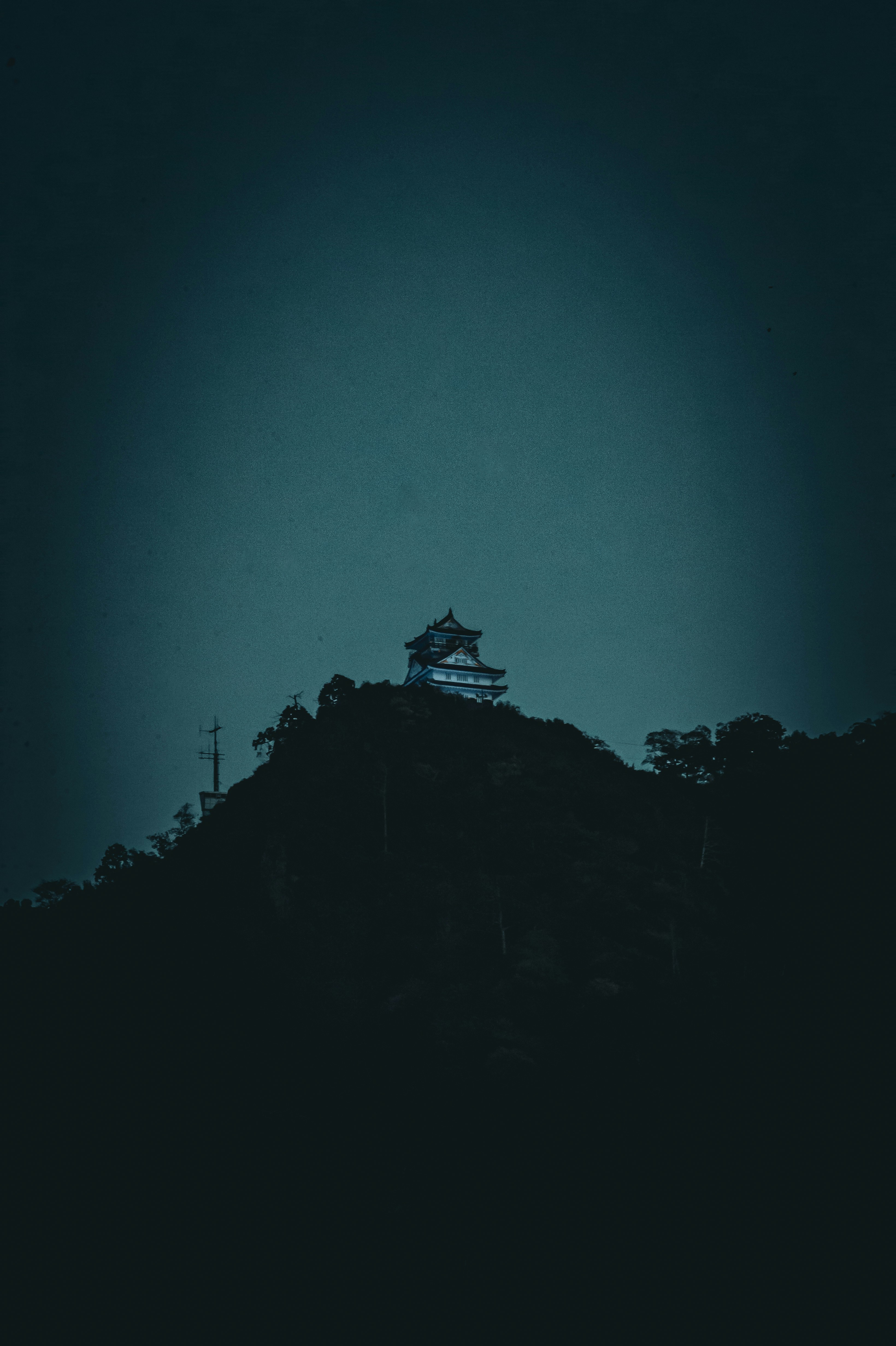 Azure Twilight Summit: A lone pagoda crowns a shadowed hill