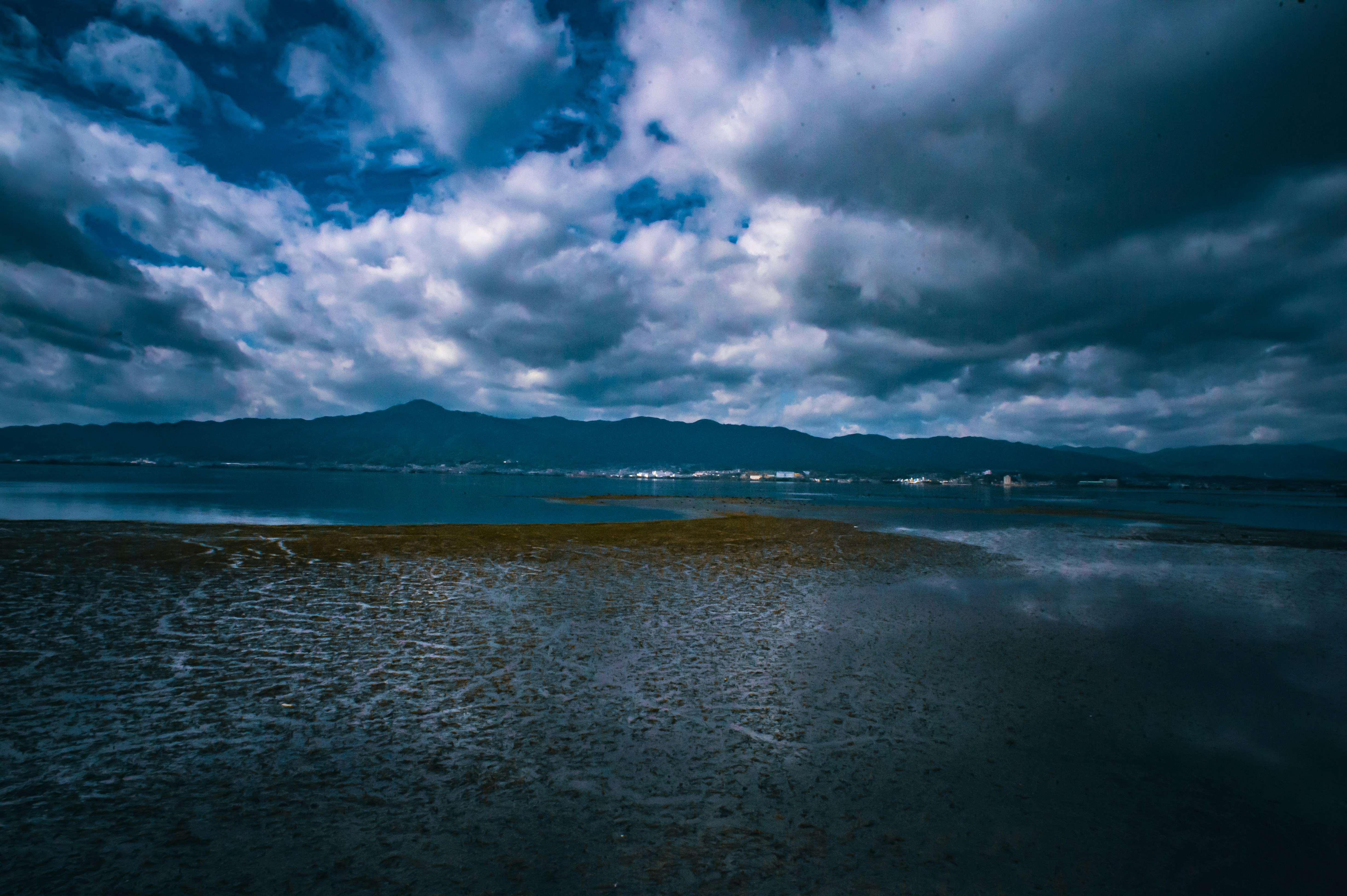 Blue Hour Rift Along a Cloud-Wrapped Shoreline