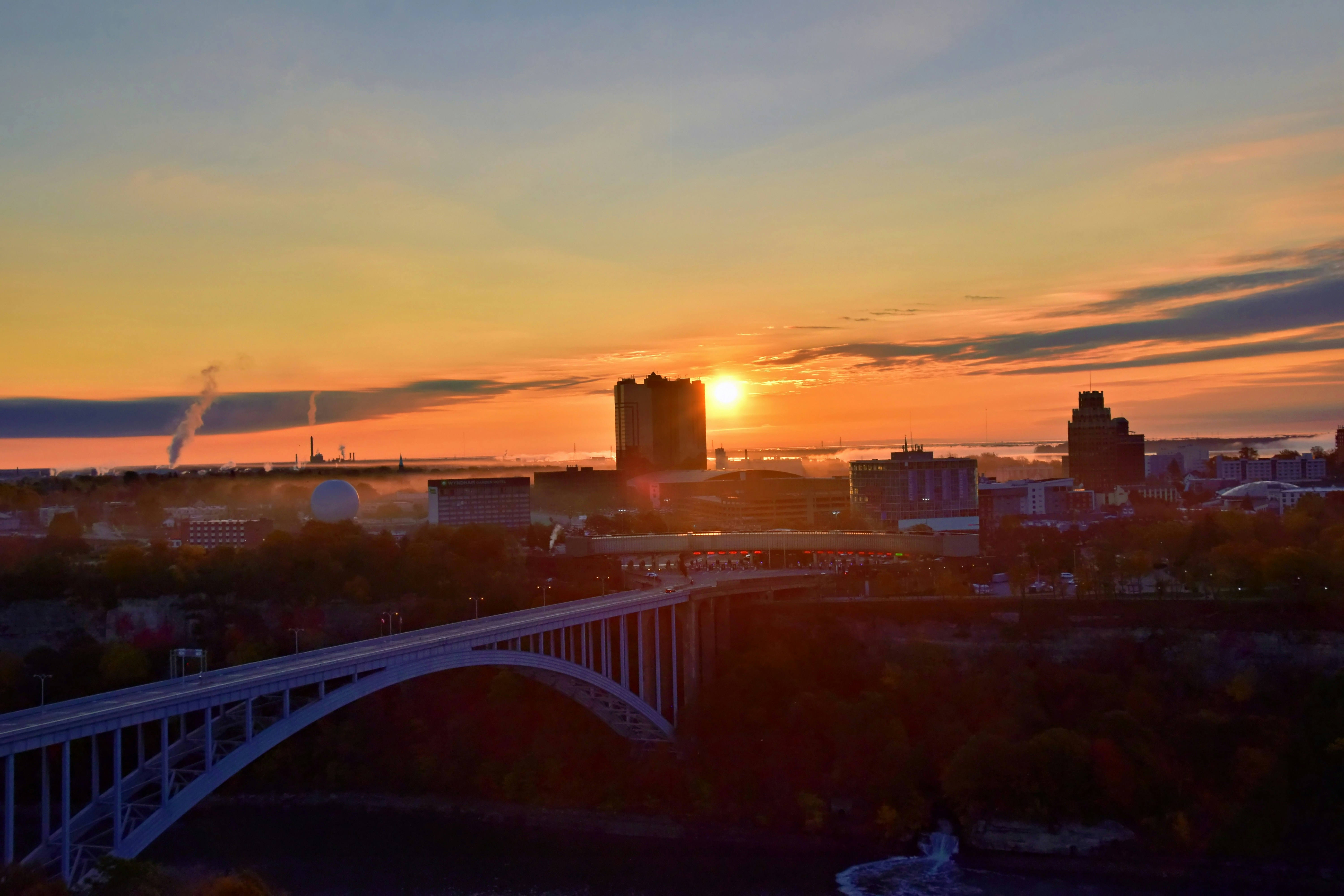 Dusk Over Arched Bridge: Sunlit City Emerges