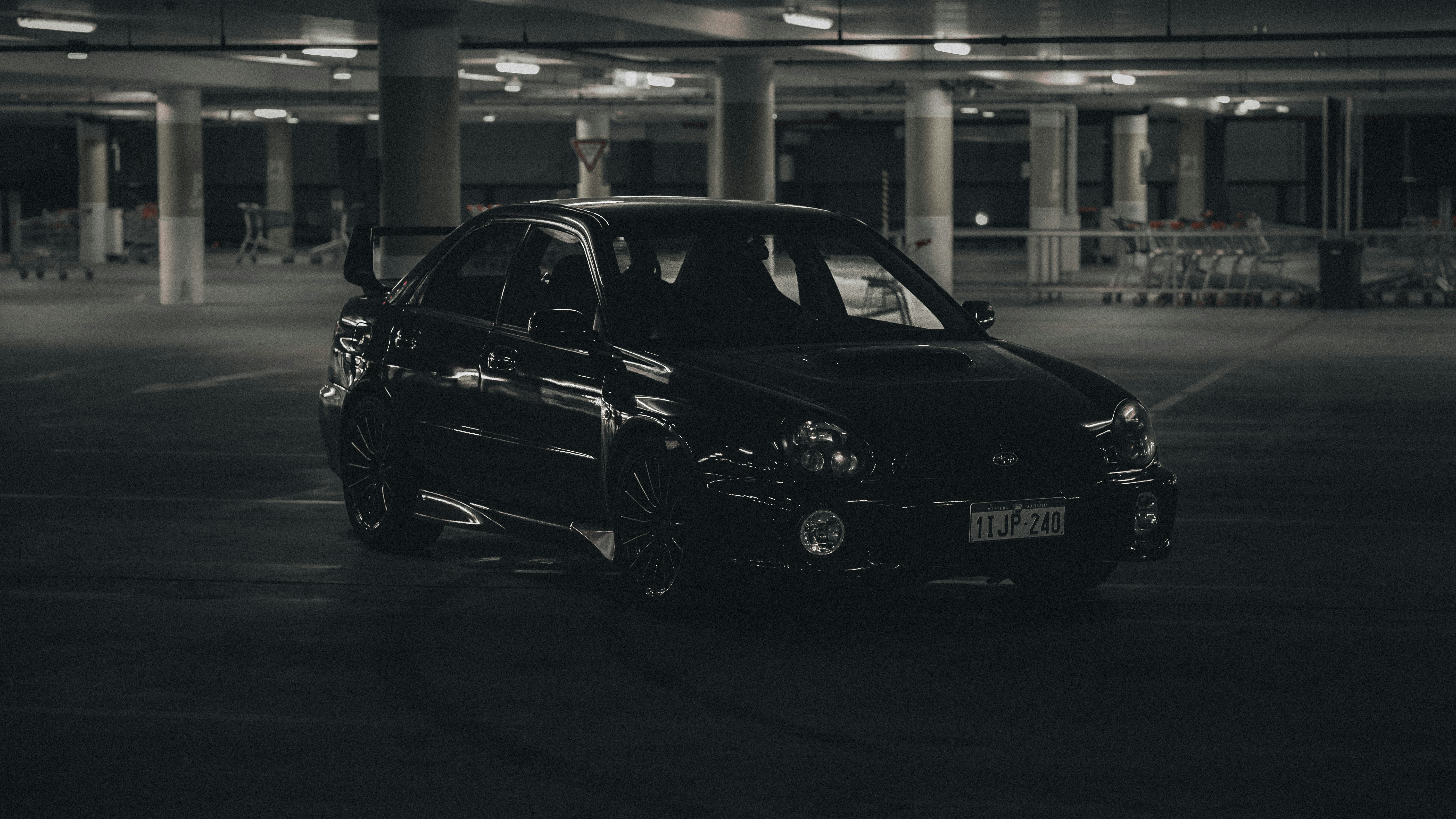 Noir Stance: A Sedan Quietly Halts in an Empty Parking Garage