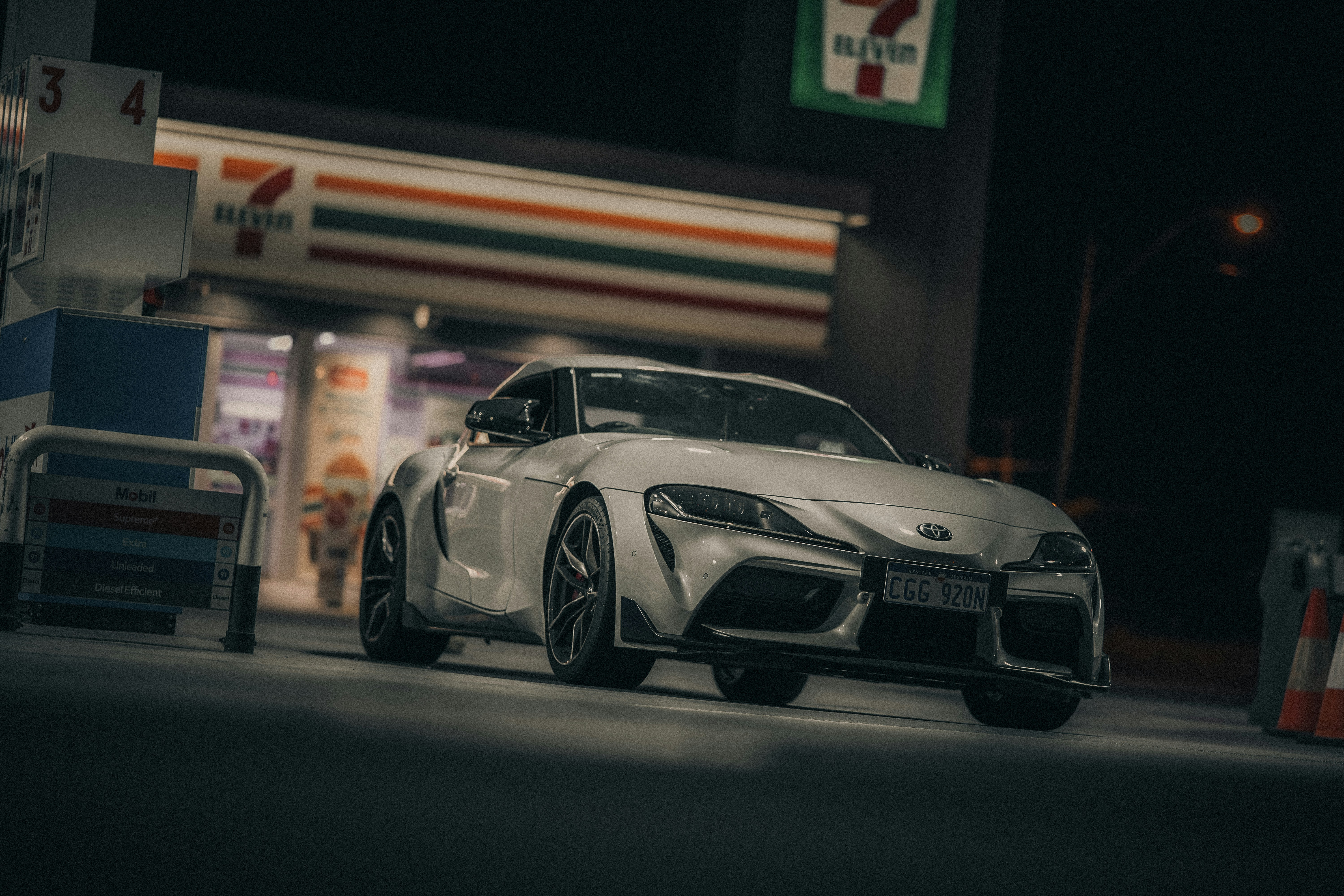 Midnight Pulse at the Pump: A silver sports coupe under neon glow