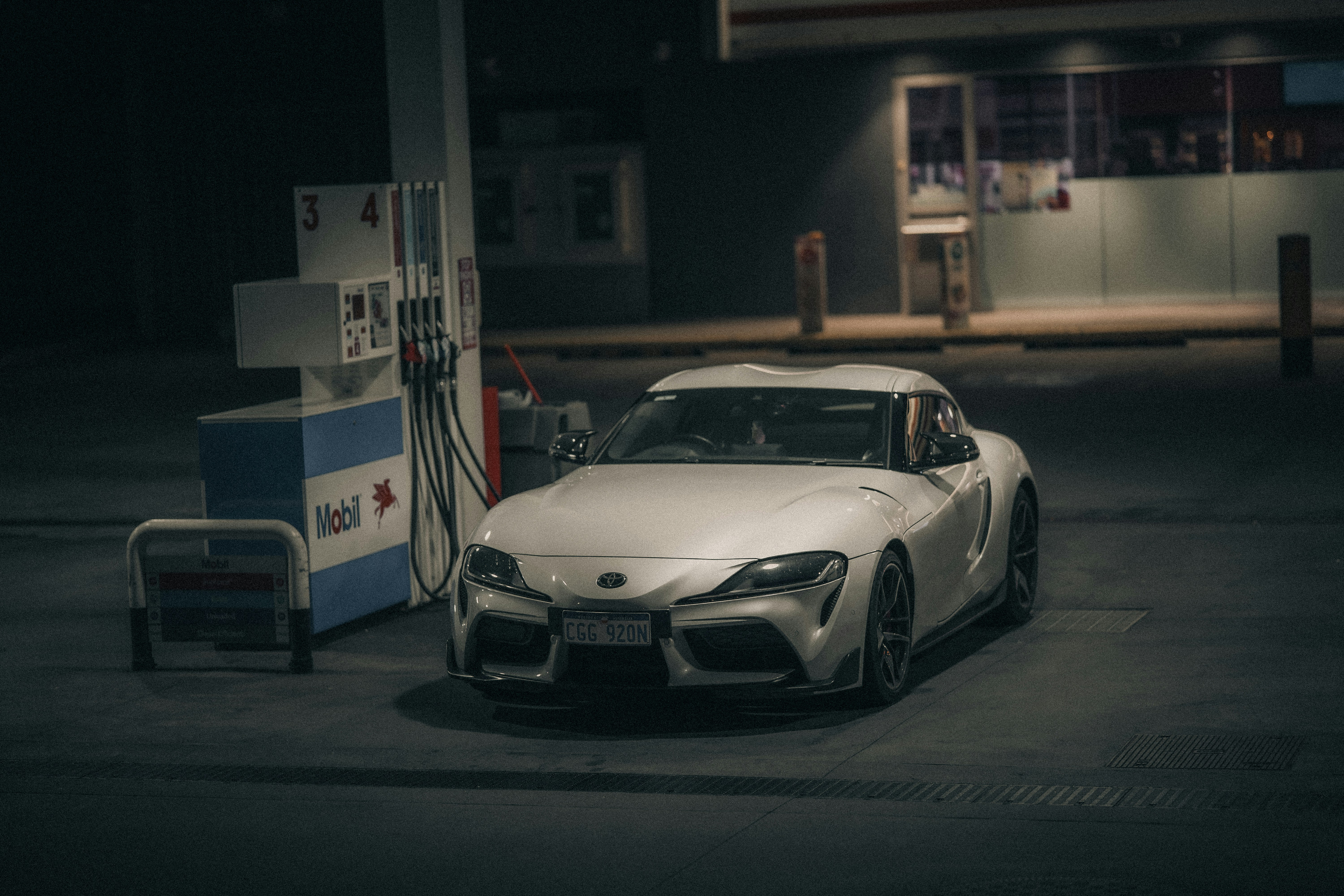Midnight Torque: A Silver Sports Car at a Quiet Neon Gas Stop