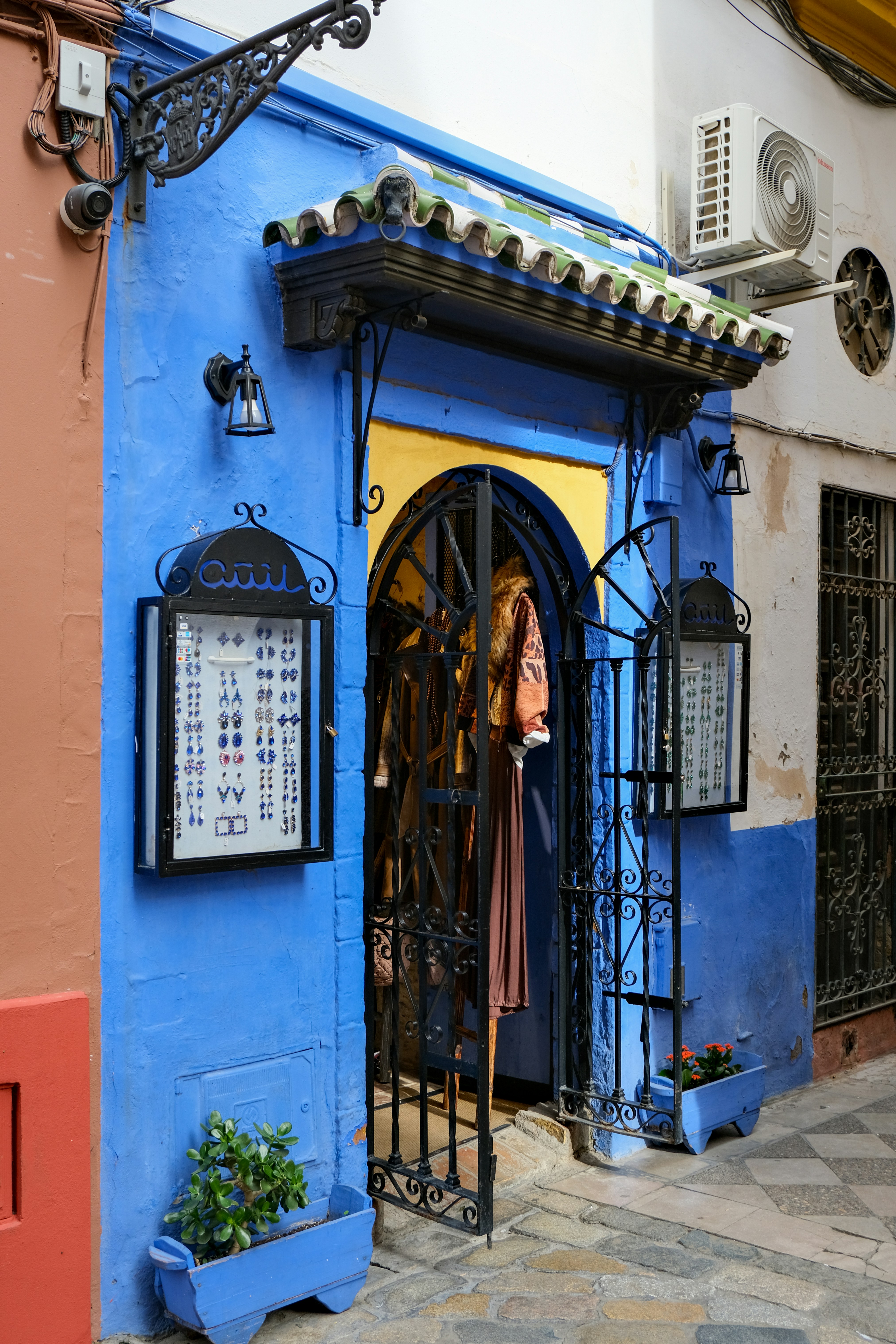 Azure Archway Boutique: Dresses Framed by Blue Walls and Iron Gates