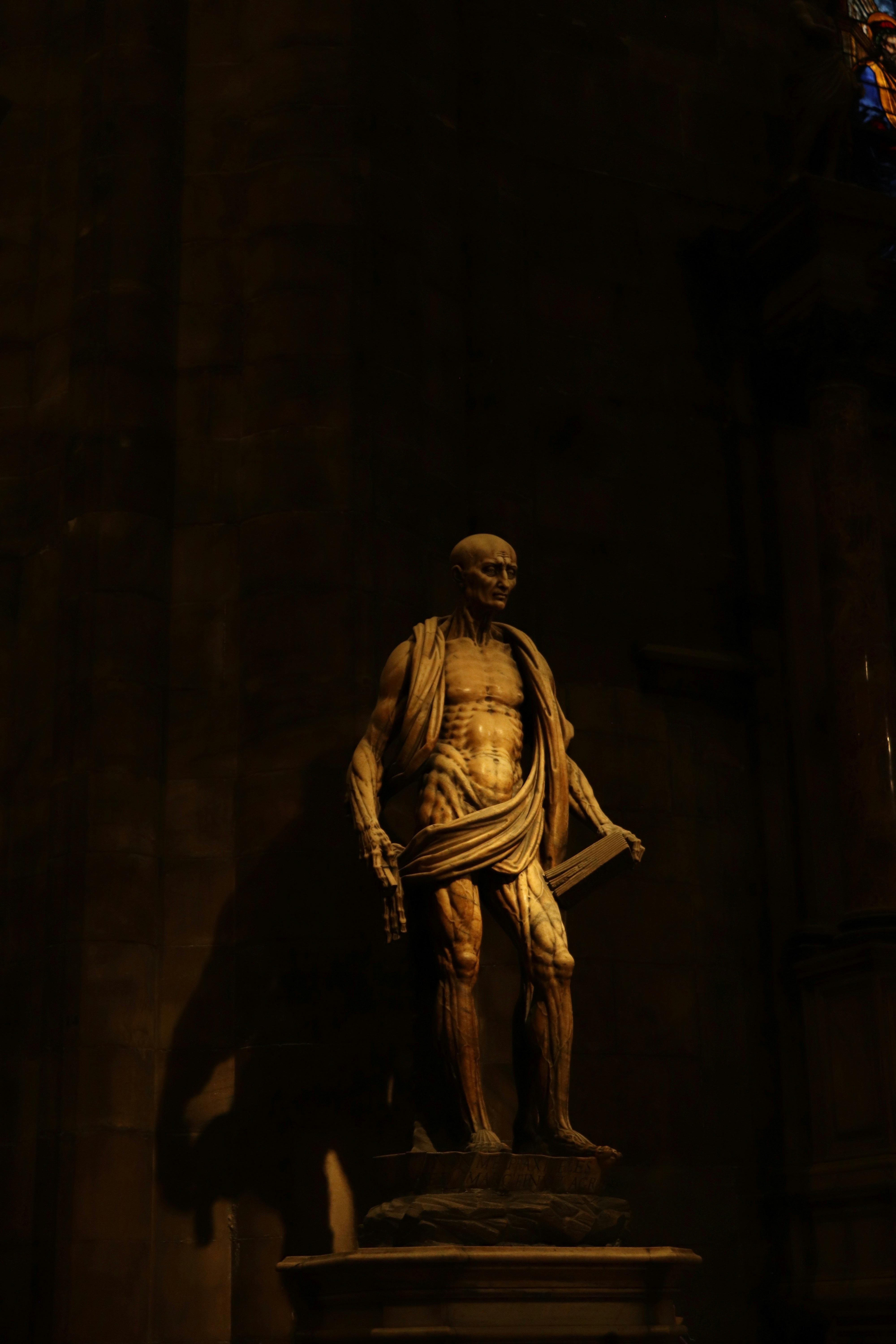 Silent Sentinel Beneath Velvet Darkness: A Muscular Statue Bathed in Gold-Hued Light