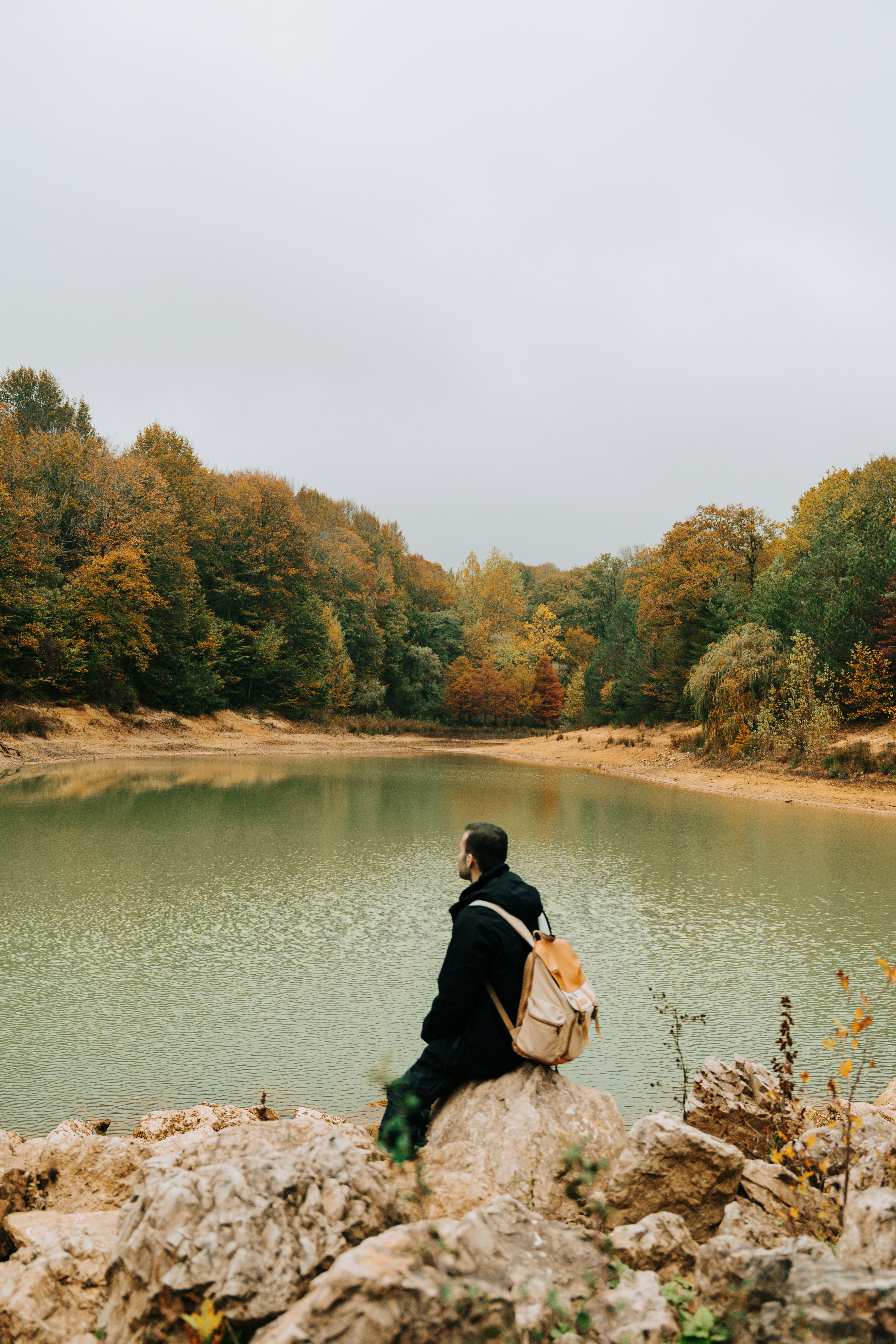Autumn Lake Reverie: A Seated Traveler at the Water's Edge