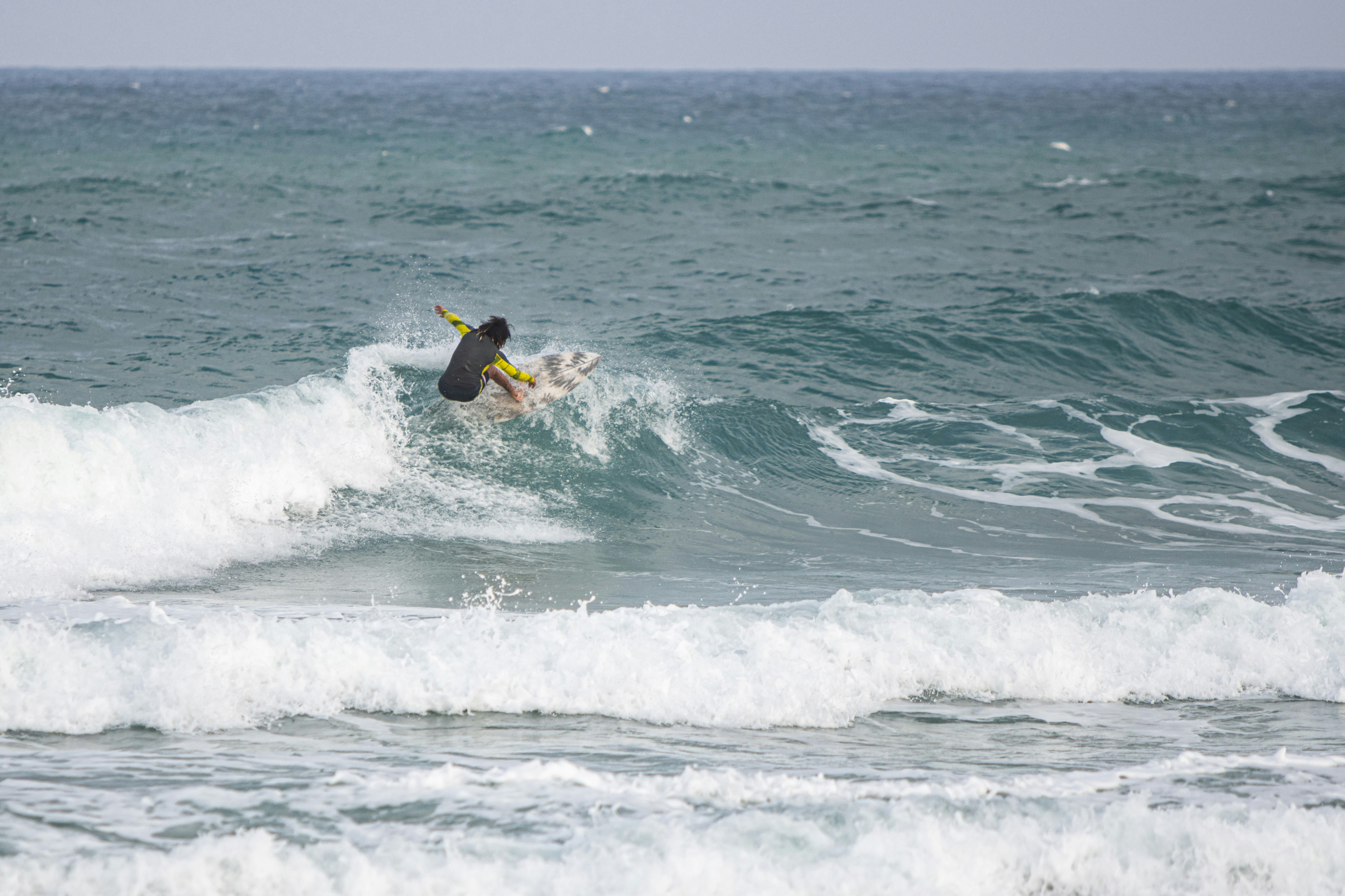 Teal Crest: Surfer threads a curling wave at dawn