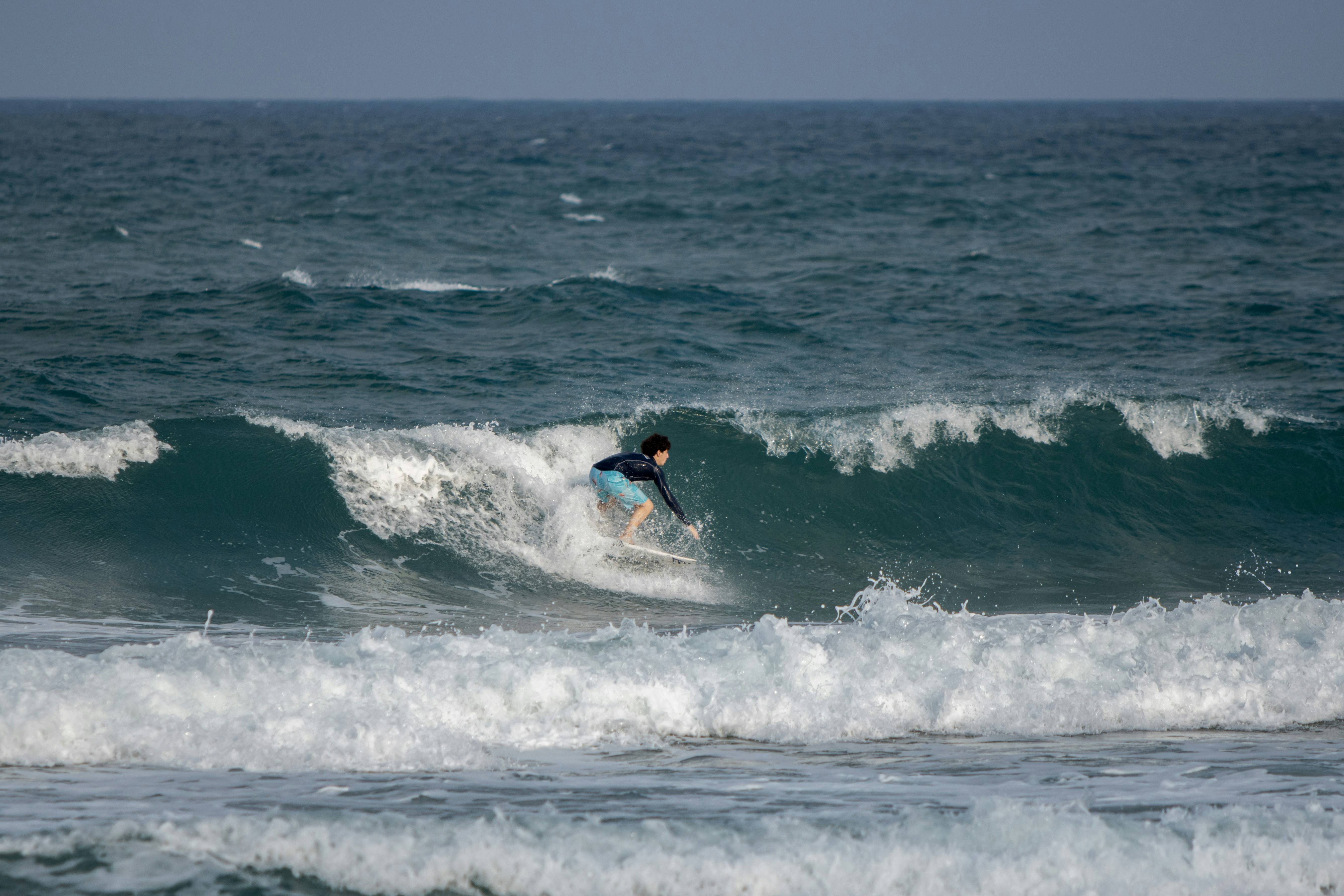 Gliding the Green Wall: A Surfer's Precise Turn Through Cresting Breaks