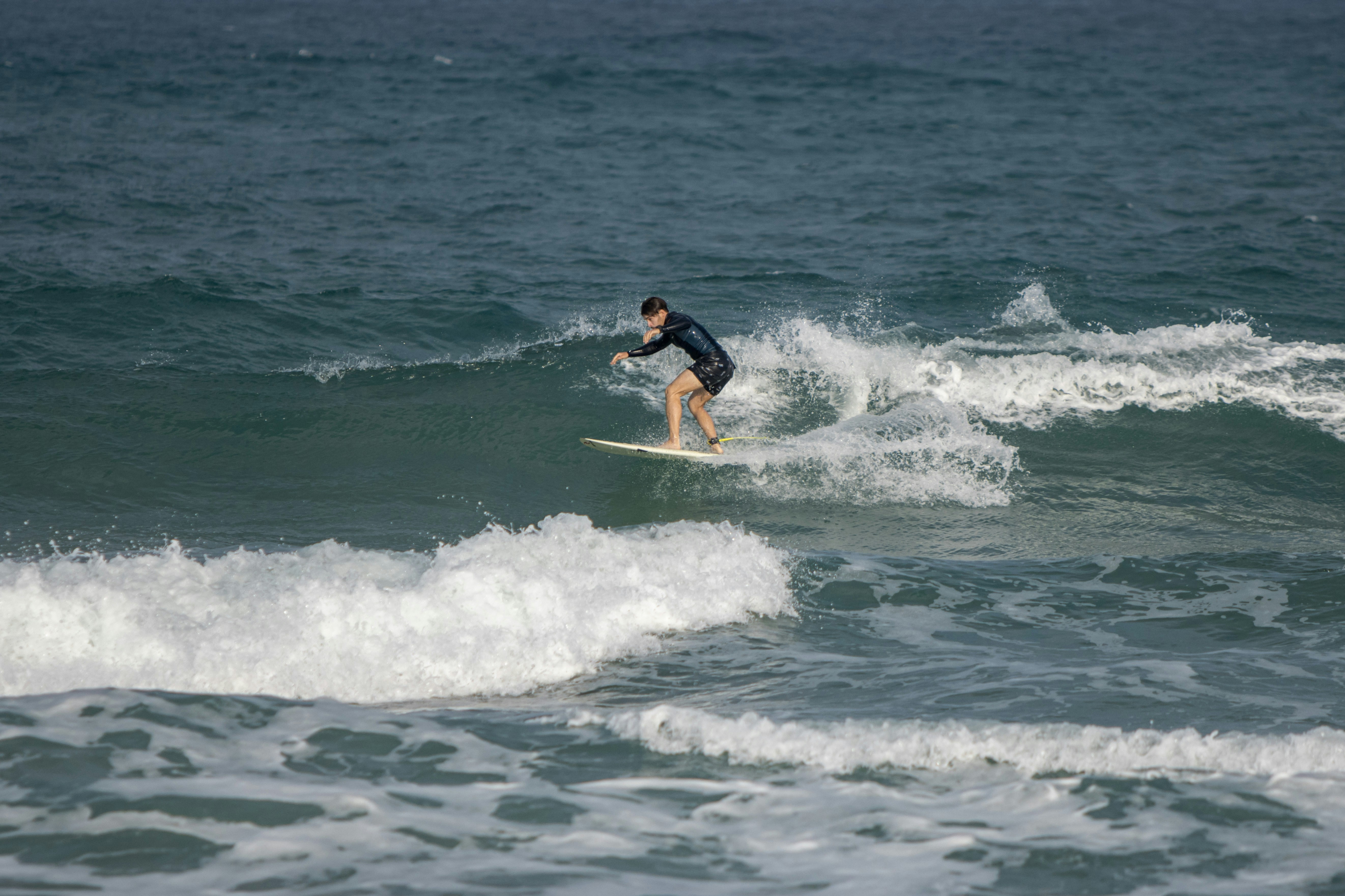 Crest Carver: a lone surfer threads a narrow blue line