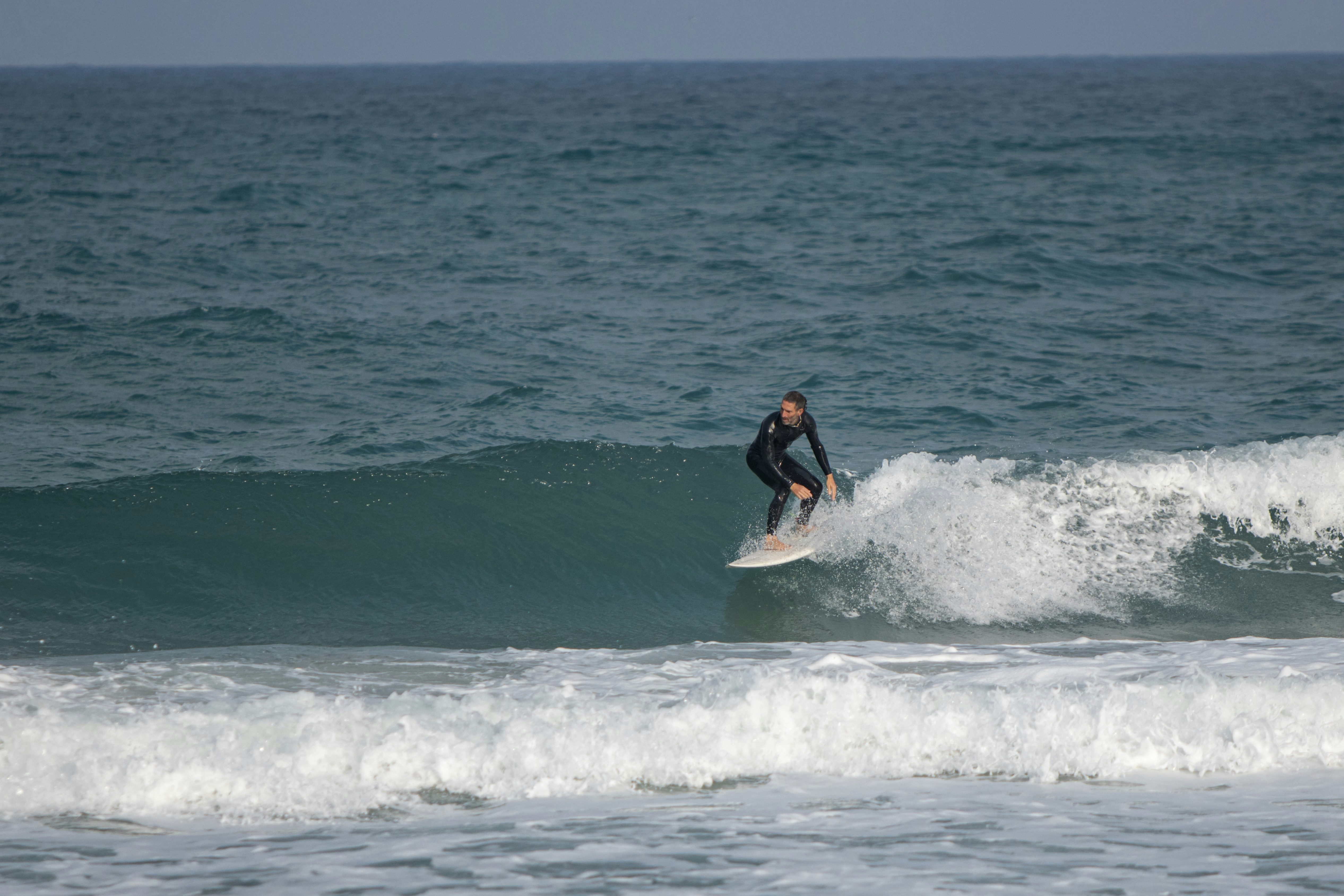 Carving the Glassy Crest: A lone surfer on a Pacific swell
