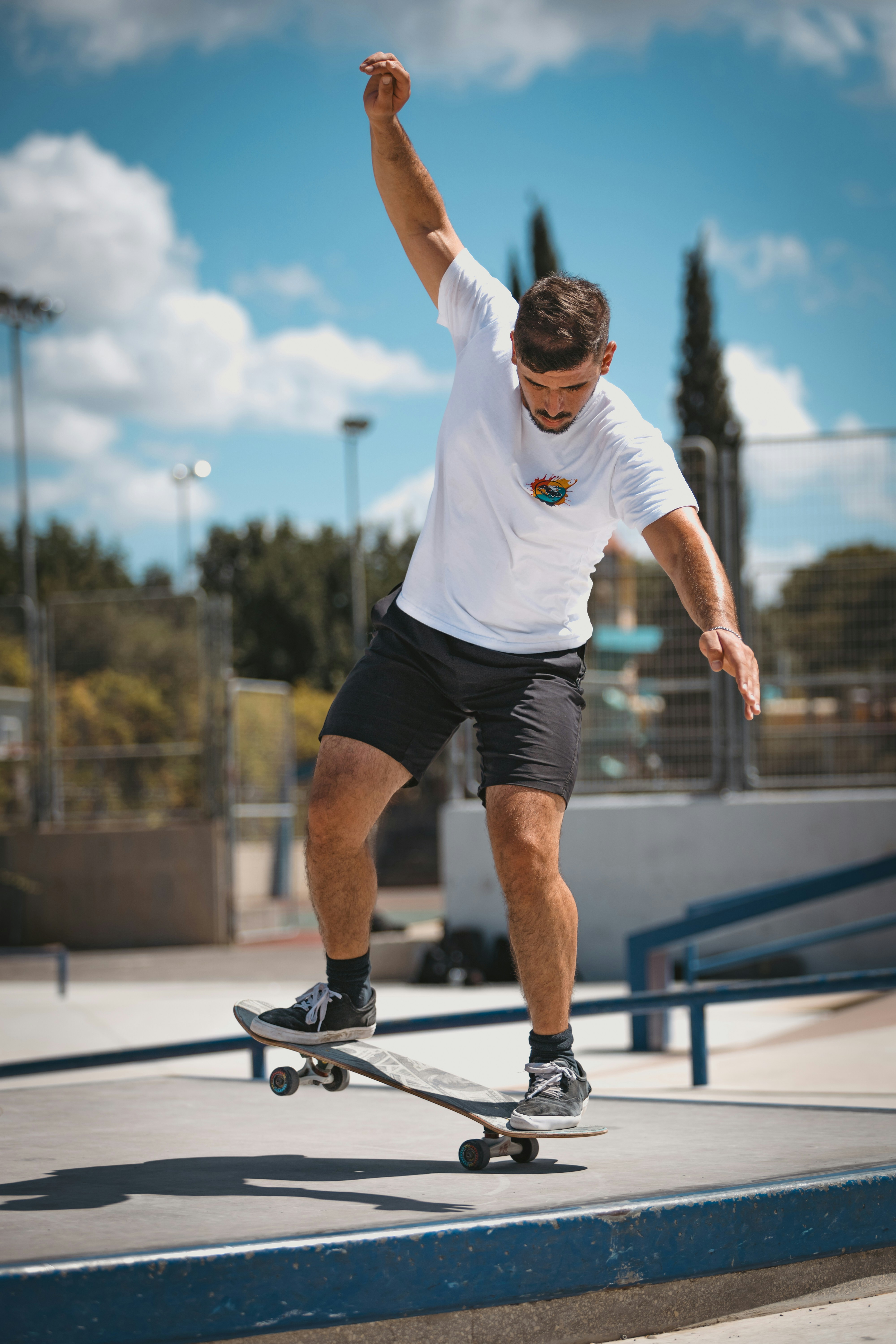 Sunlit Rail Grind: A Skateboarder's Precision in the Park