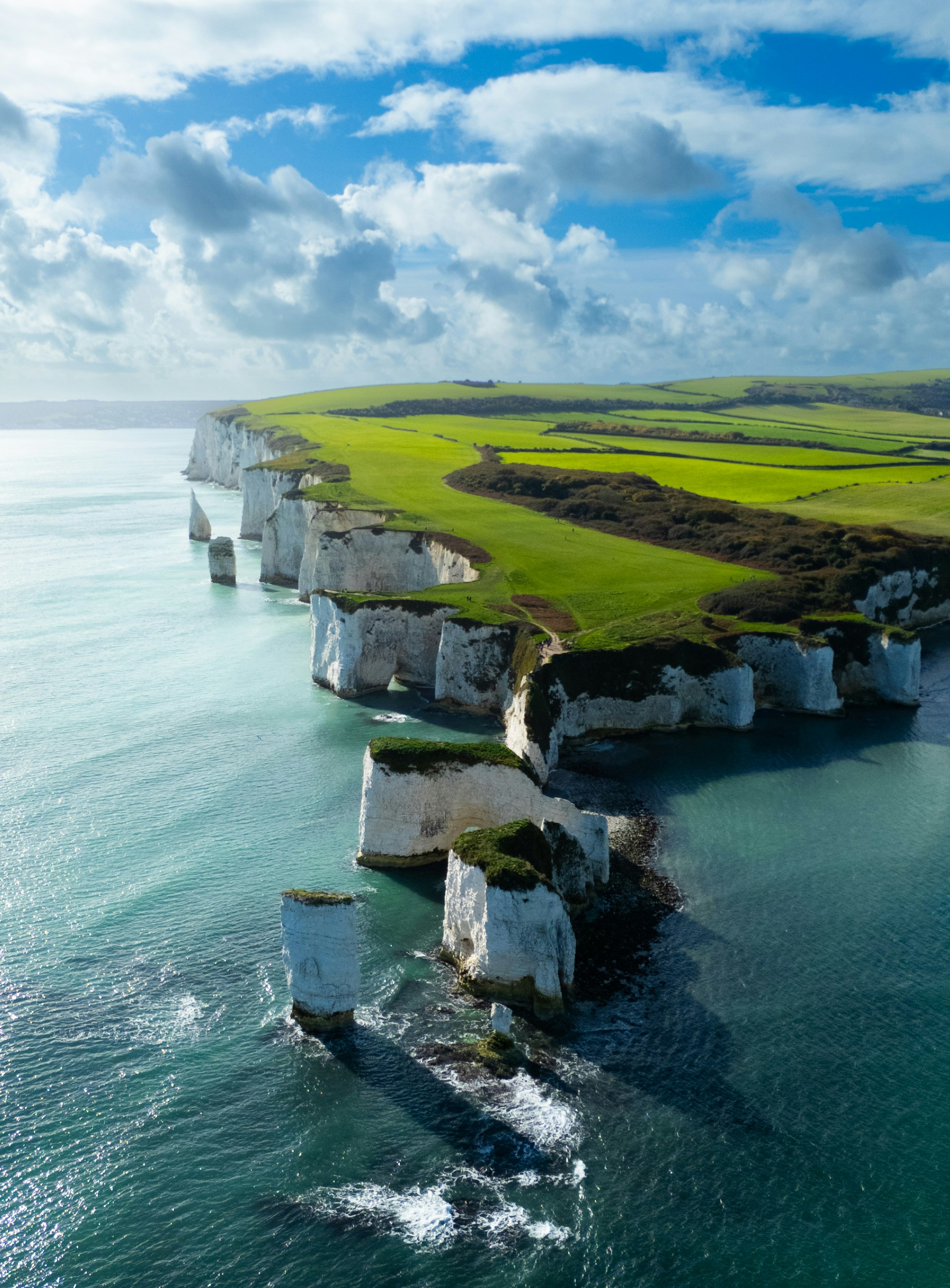 Emerald Edges: Aerial View of White Chalk Cliffs and Turquoise Sea