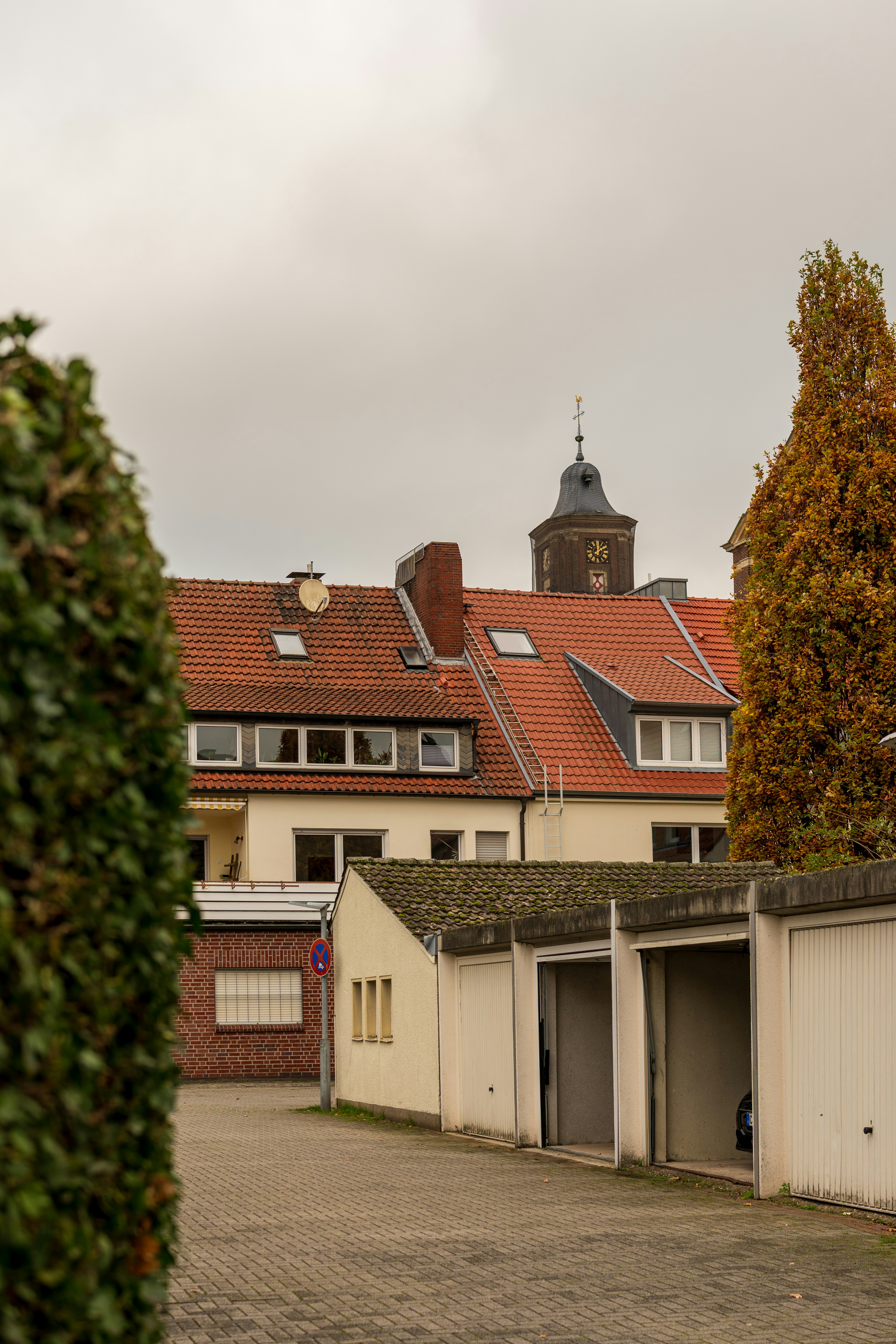 Clocktower Above Red-Tiled Rooftops in a Quiet Autumn Street