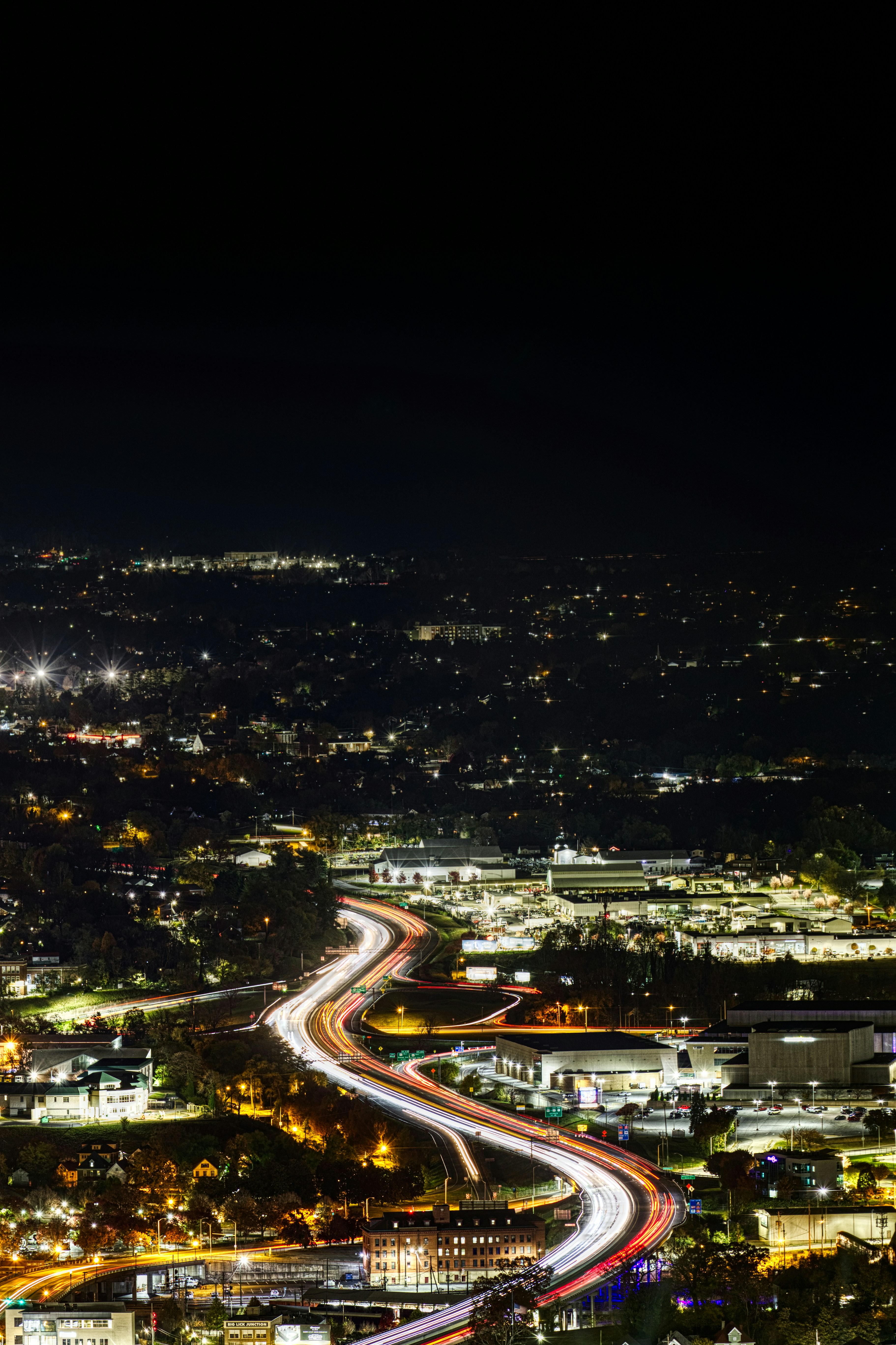 Light-Ribbon Corridor: Nighttime Highway Through a Winding Cityscape