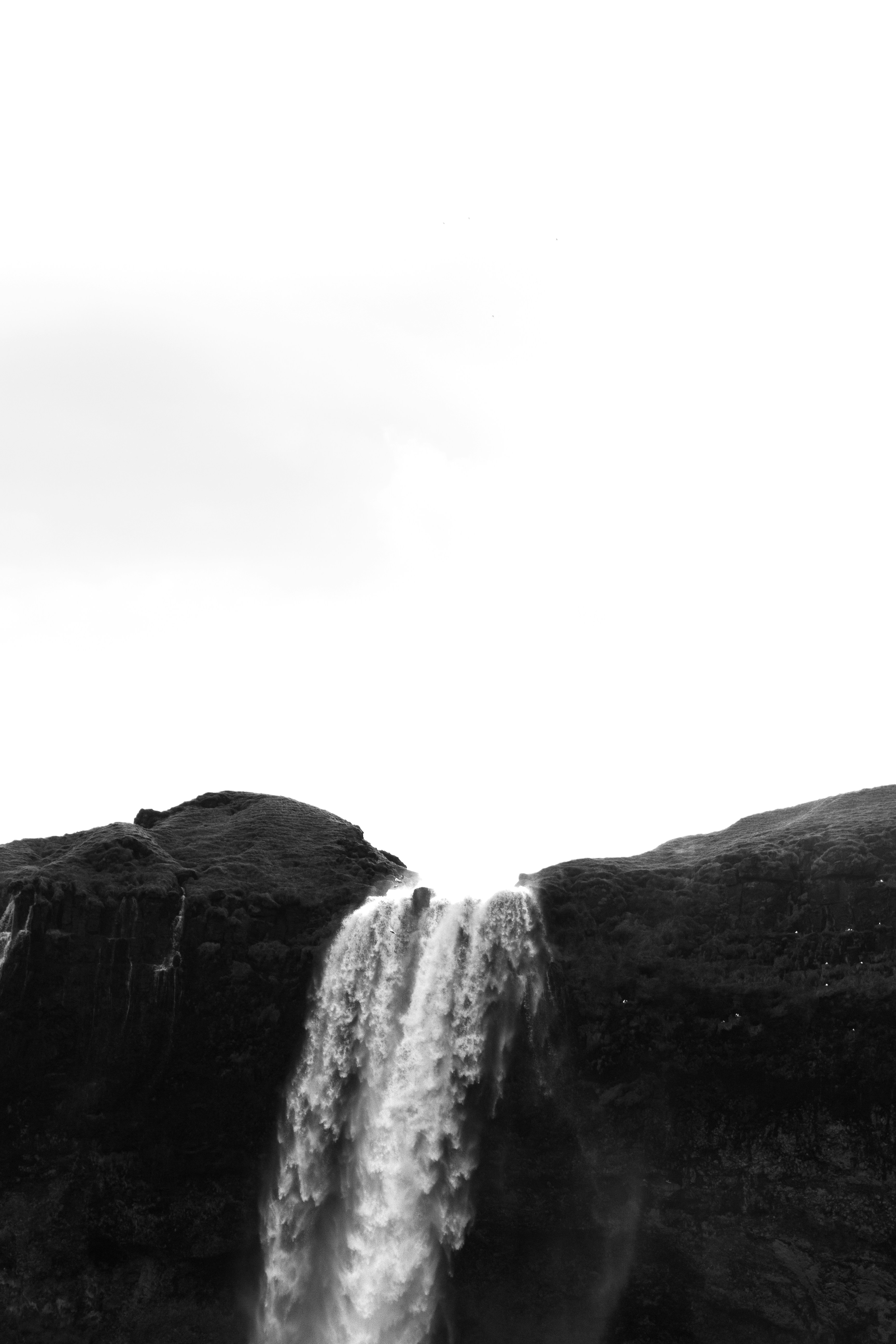 Monochrome Cascade Between Rugged Basalt Cliffs
