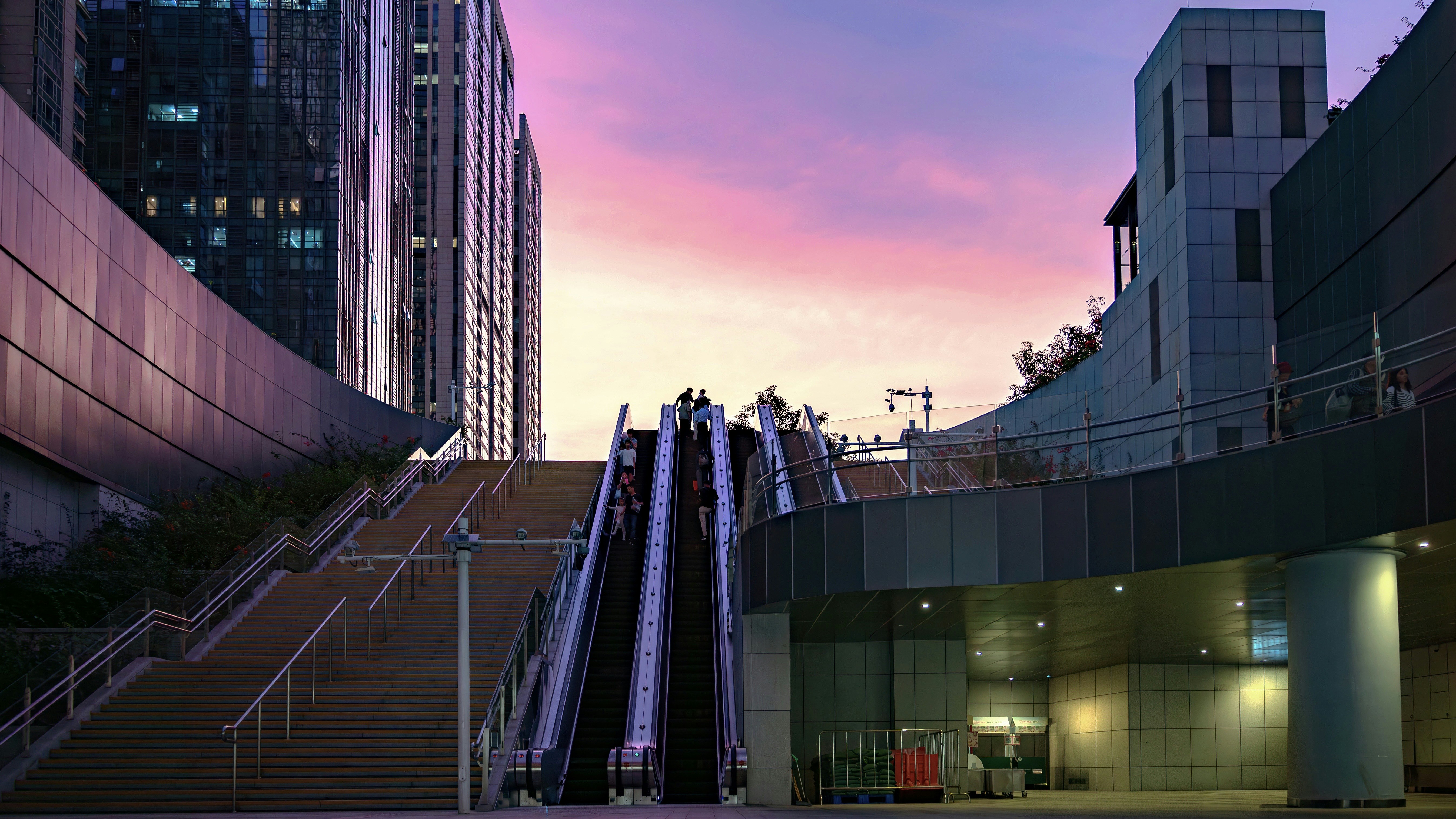 Dusk Corridor: Escalators Leading the City Toward a Pink Horizon