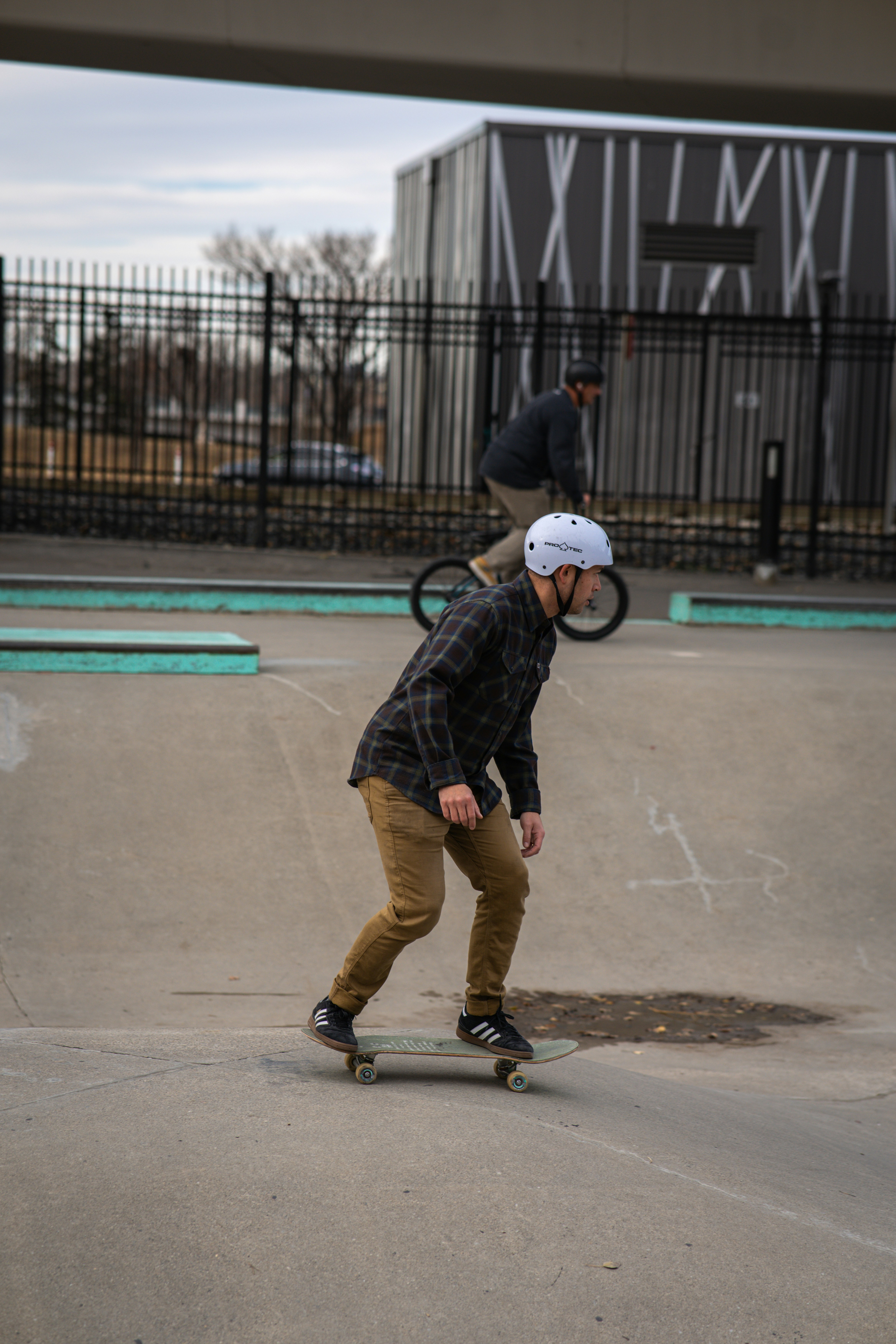 Plaid Skater in Focus: A Quiet Glide Through an Industrial Skate Park