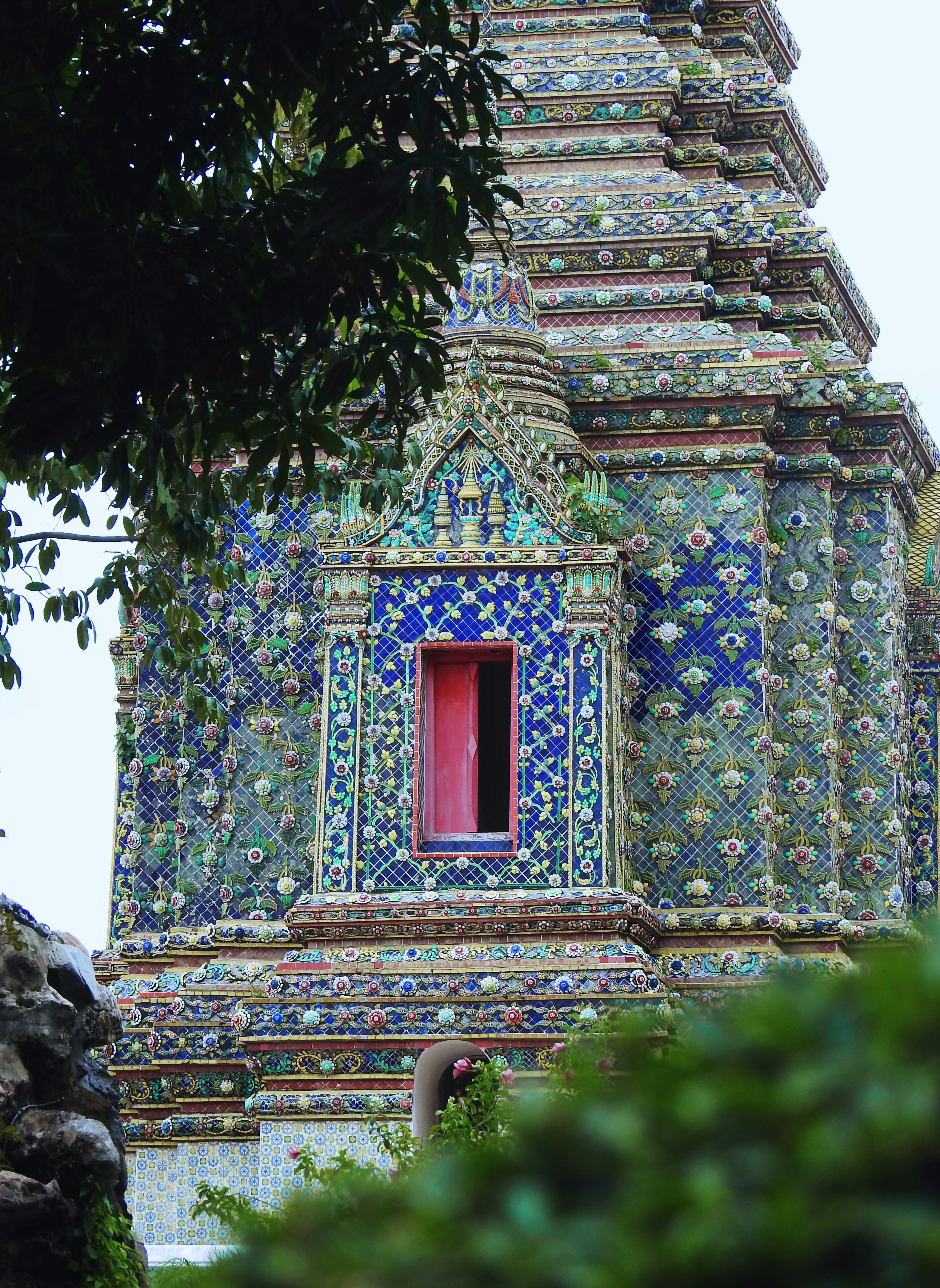Crimson Niche Framed by Cerulean Mosaic: A Temple Facade in Colorful Tilework