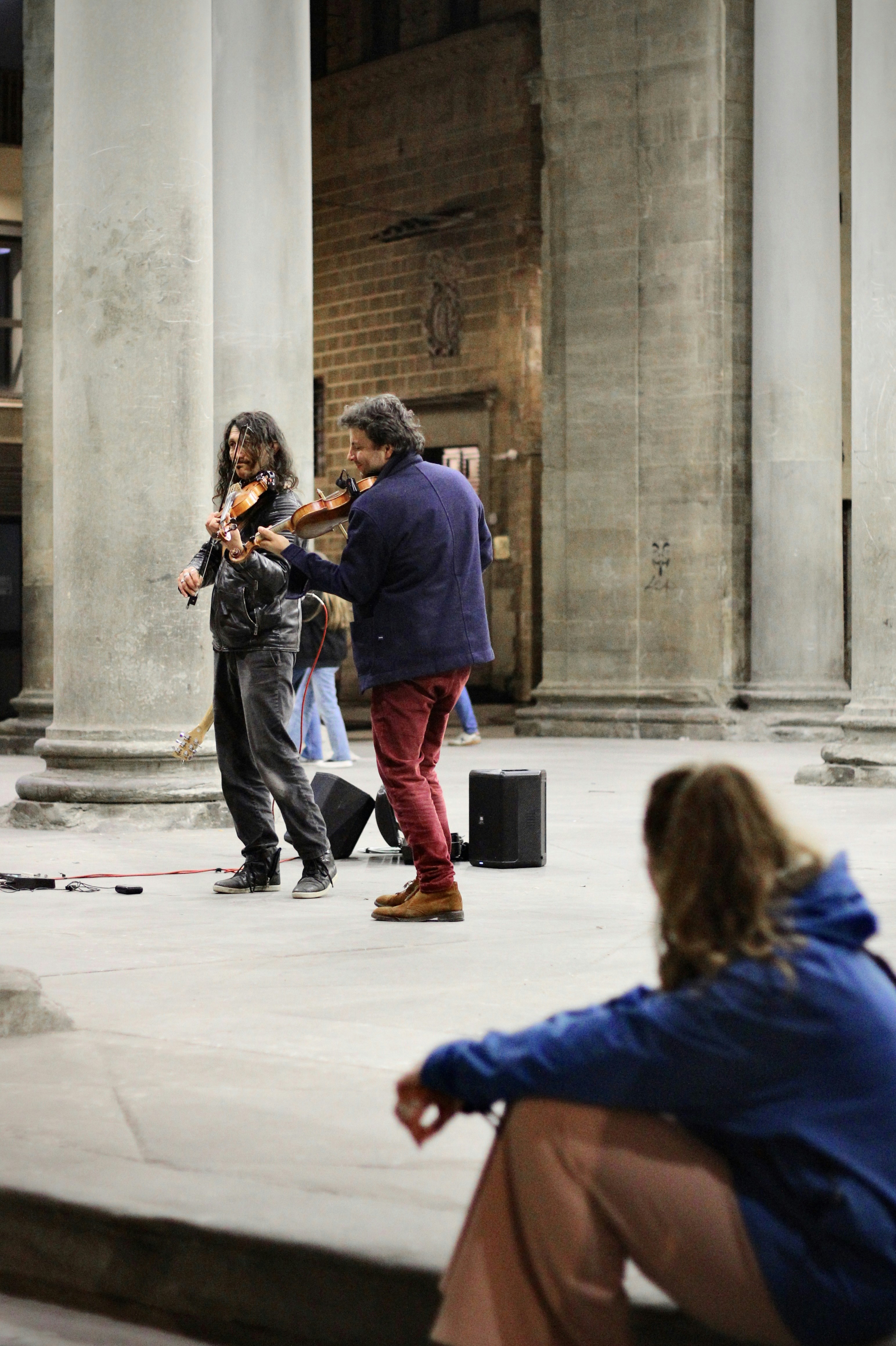 Arches and Aria: Street Violin Duo Under a Stone Portico