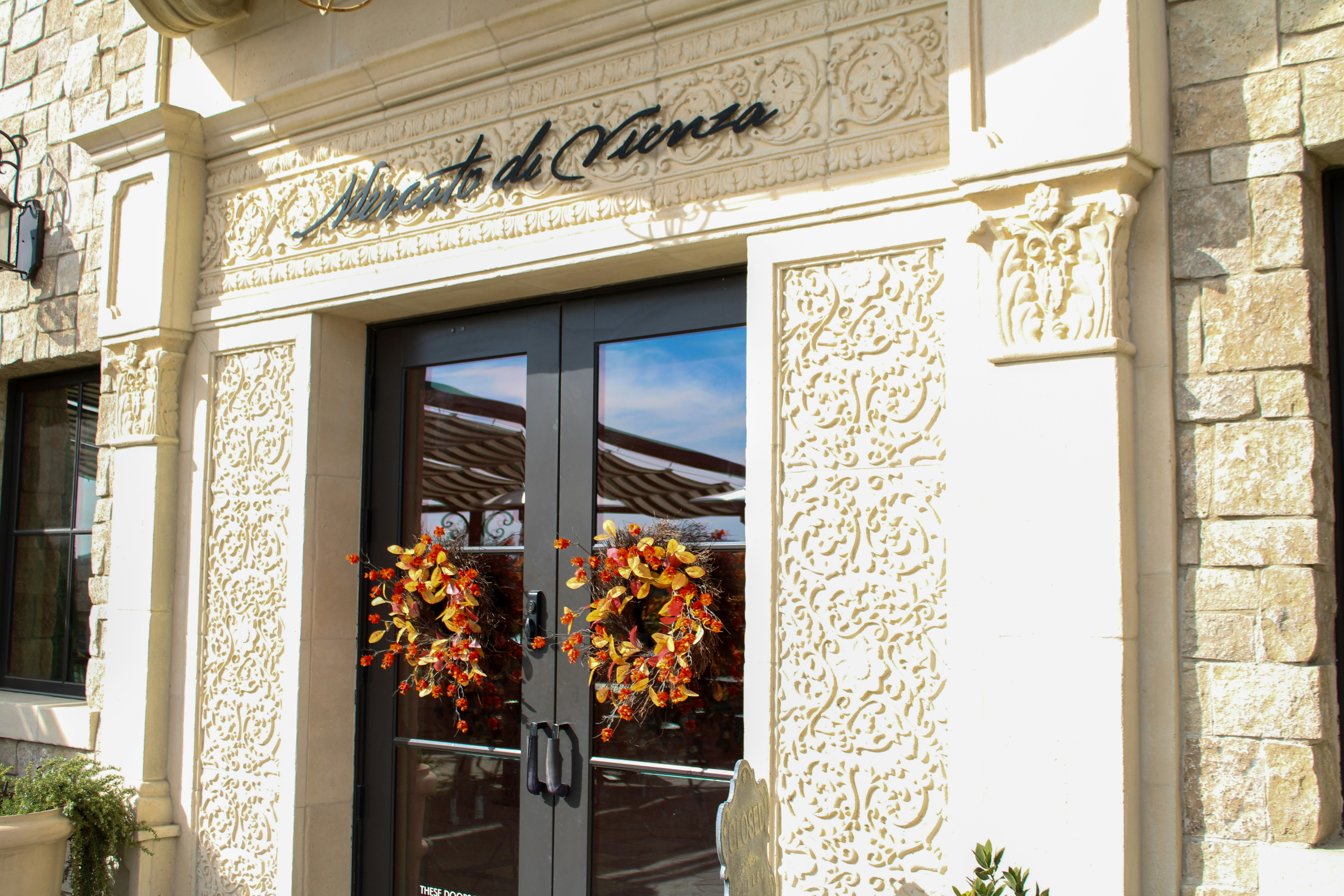 Autumn Wreaths Framing a Stone-Carved Boutique Entrance