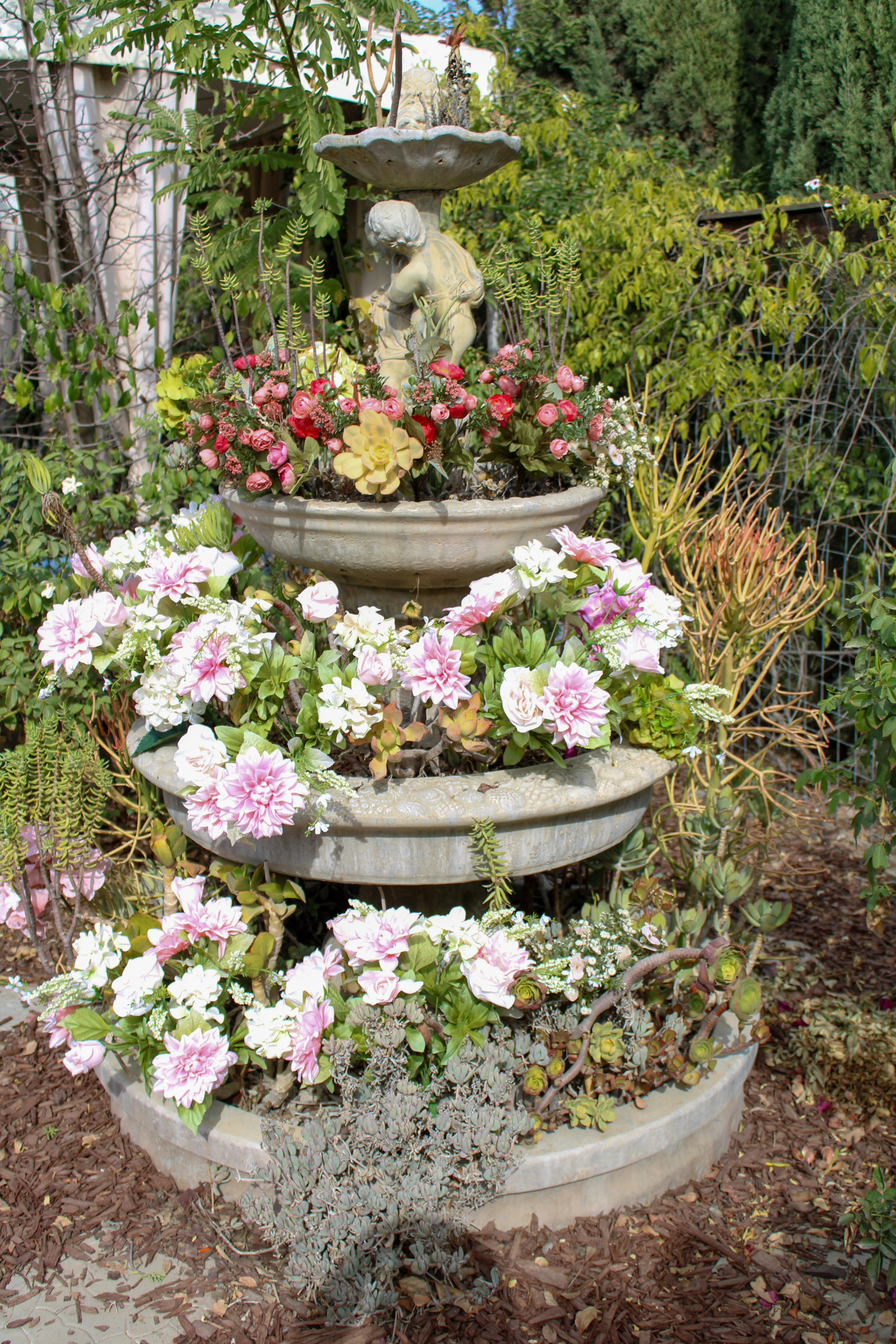 Petaled Cascade: A Stone Garden Fountain Crowned by a Statue