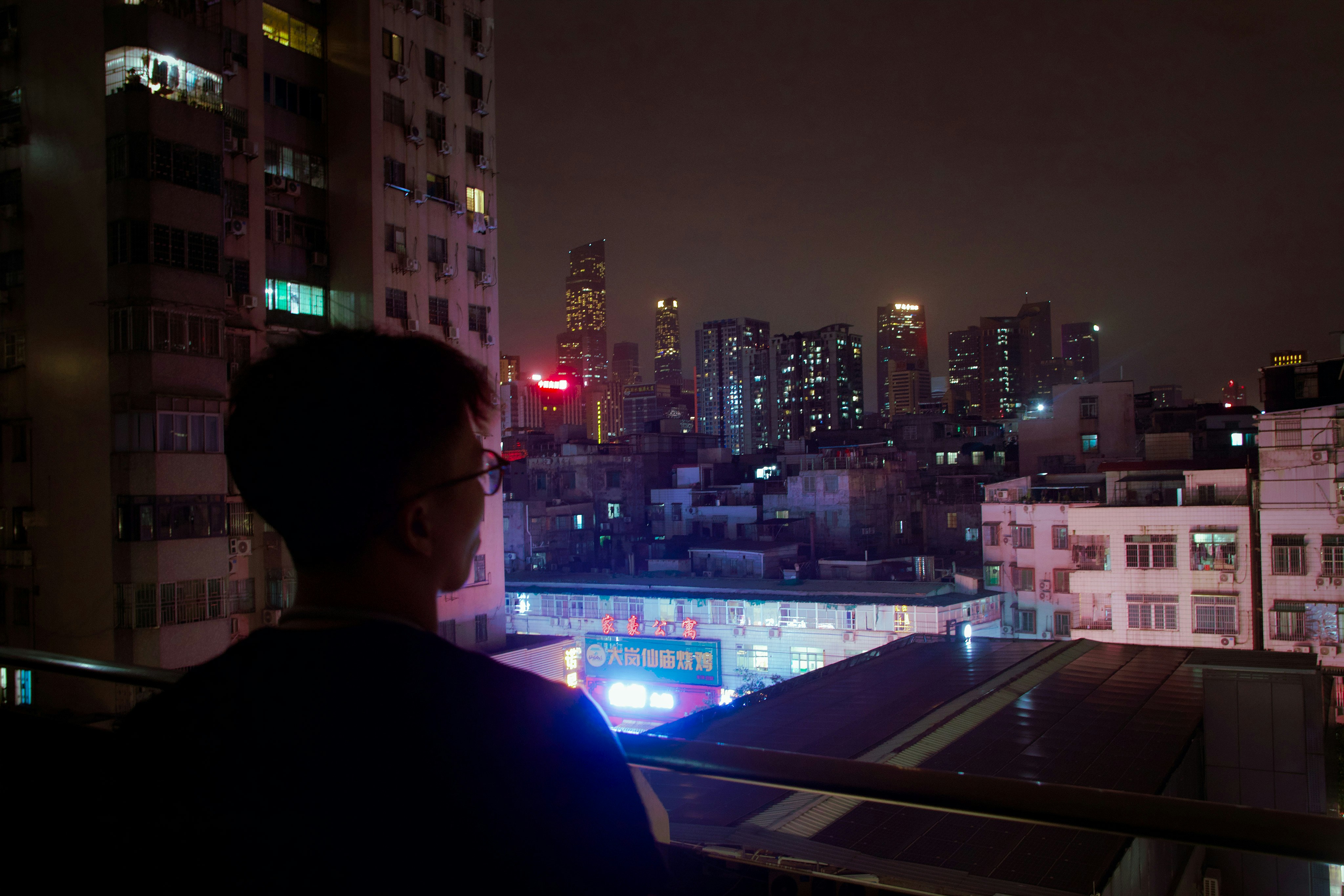 Rooftop Silhouette Framing a Neon-Dusted City Skyline