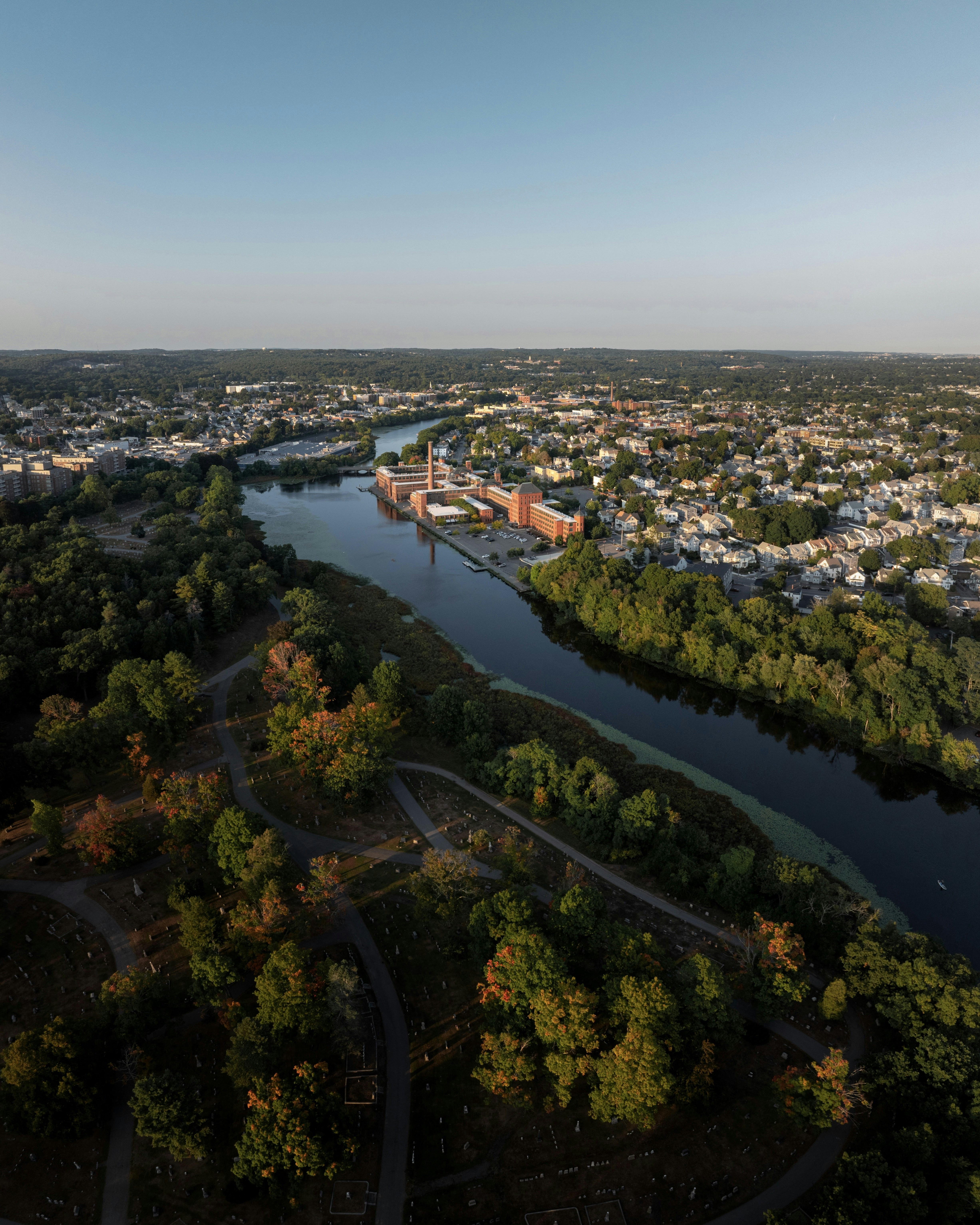 Riverside Redbrick Campus: Aerial Portrait of a Winding Waterway and Green City
