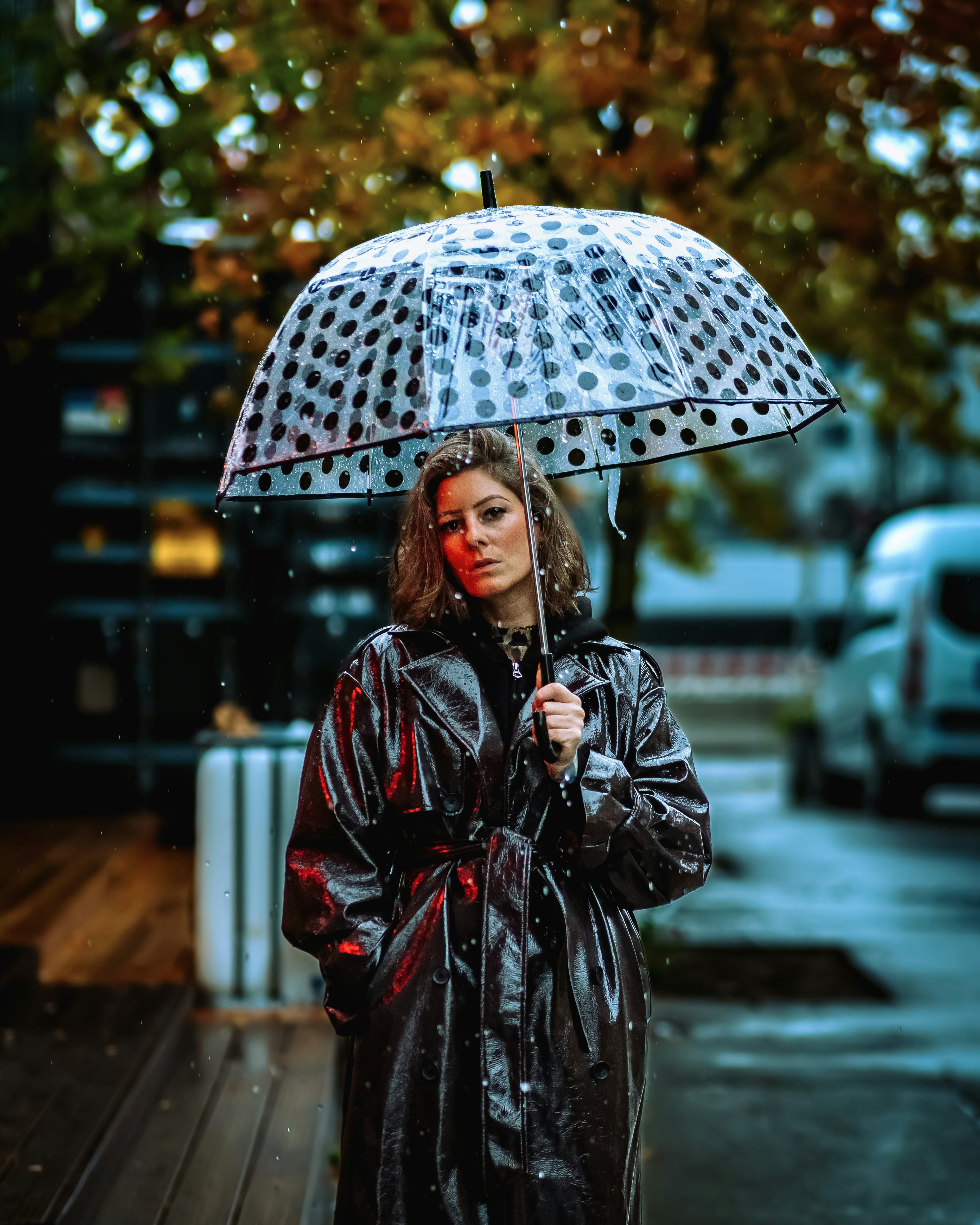 Under a Polka-Dot Umbrella: A Rain-Soaked Portrait on a Wet City Street