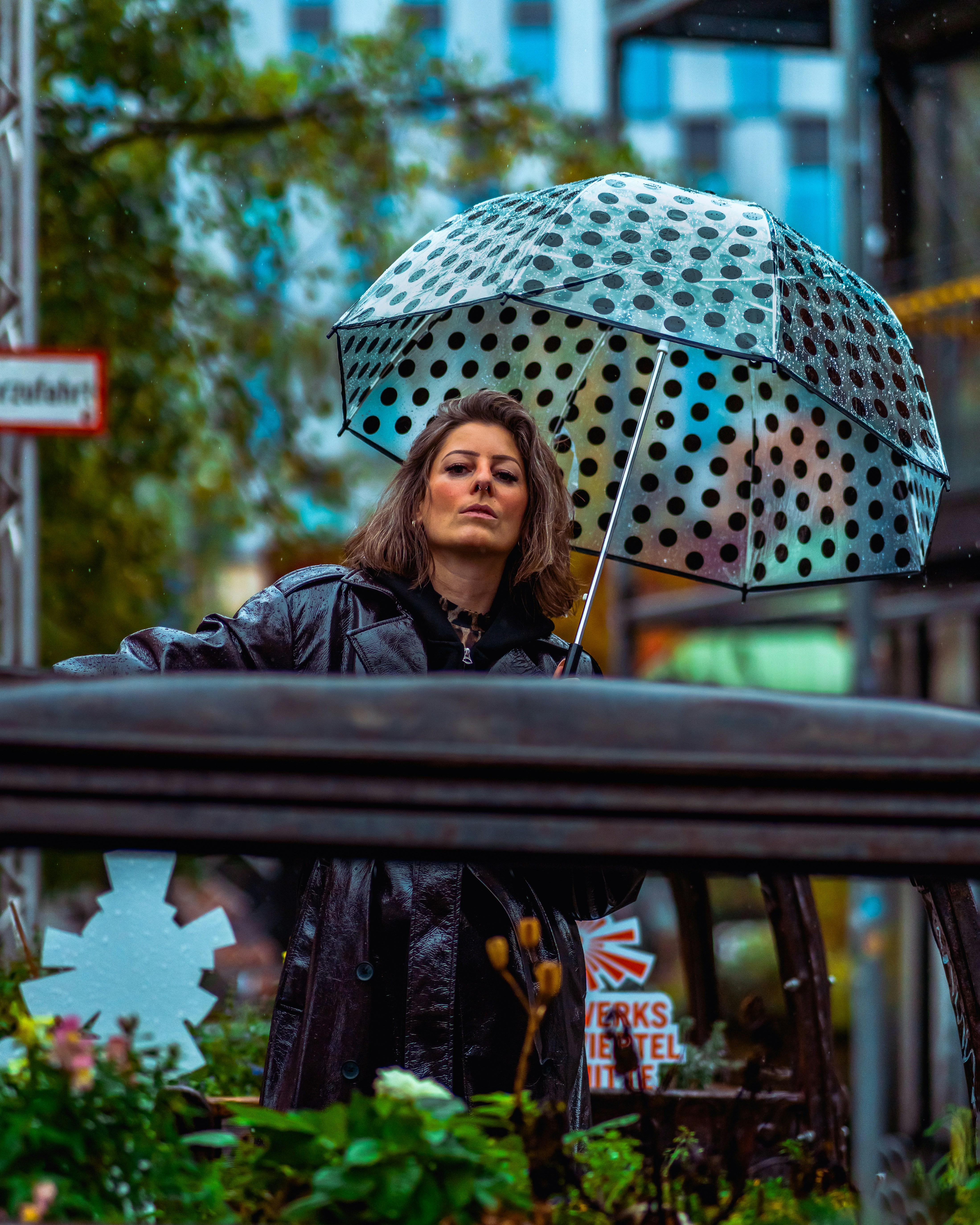 Polka-Dot Umbrella in Rain: A Quiet City Portrait Behind the Barrier
