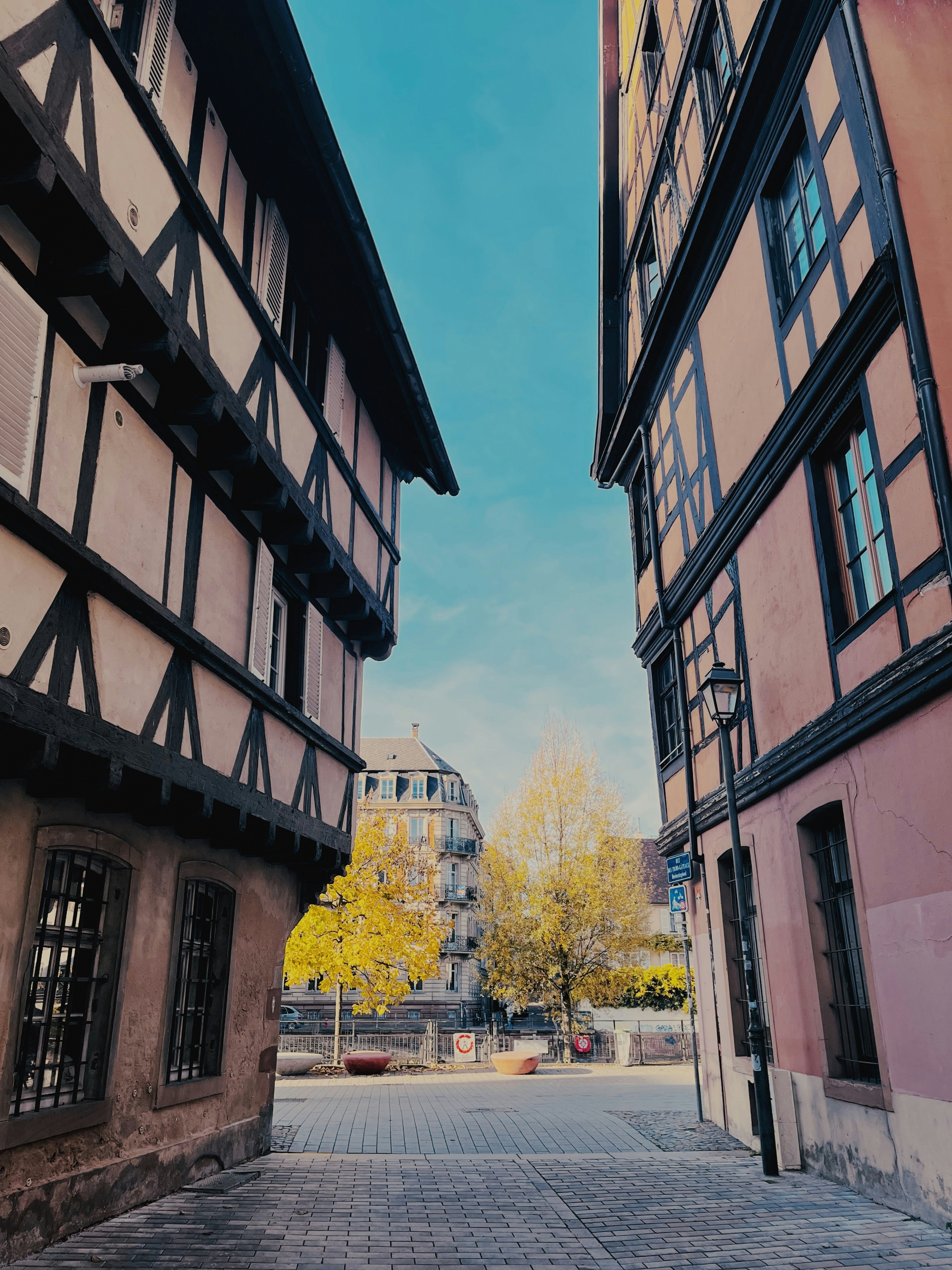 Sunlit Passage Between Timbered Facades