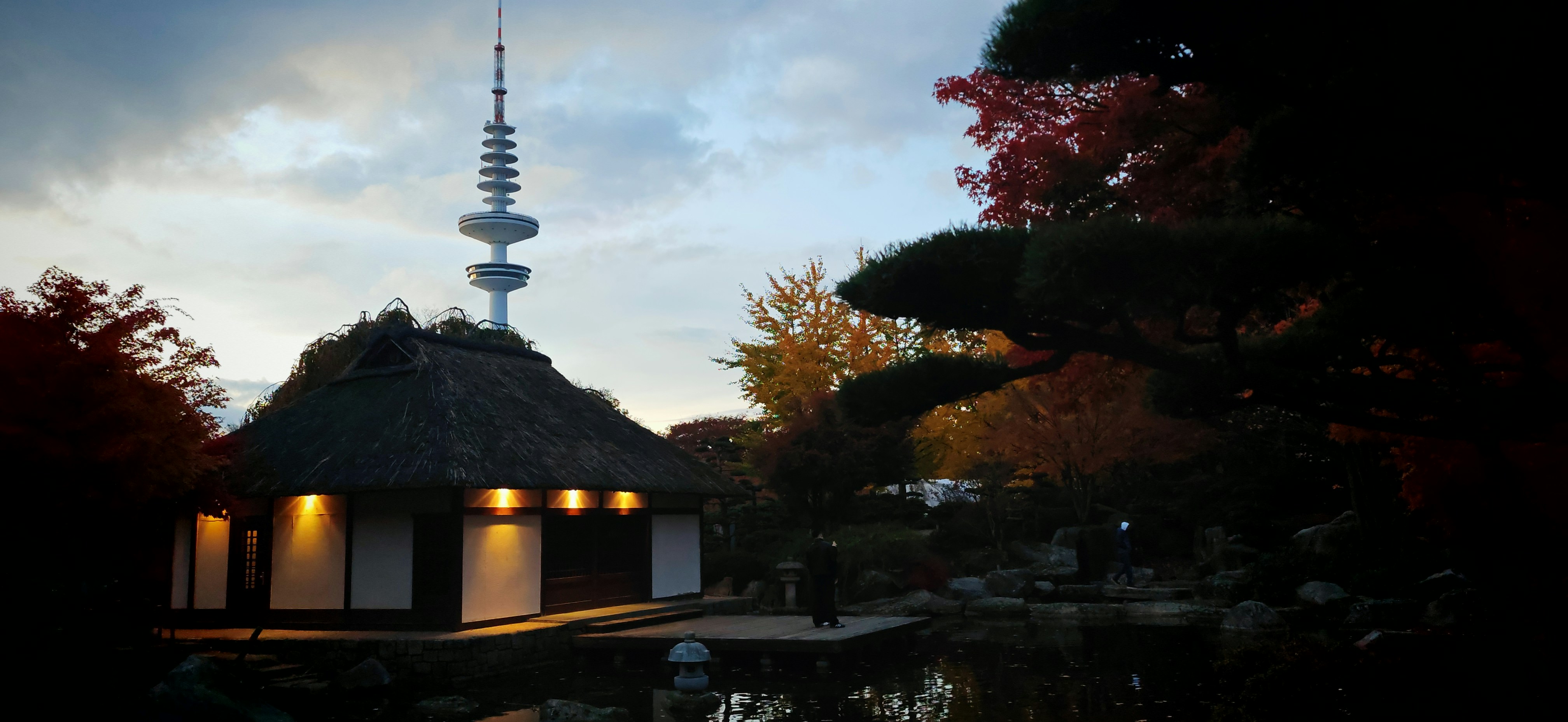 Traditional hut with tower in background at dusk