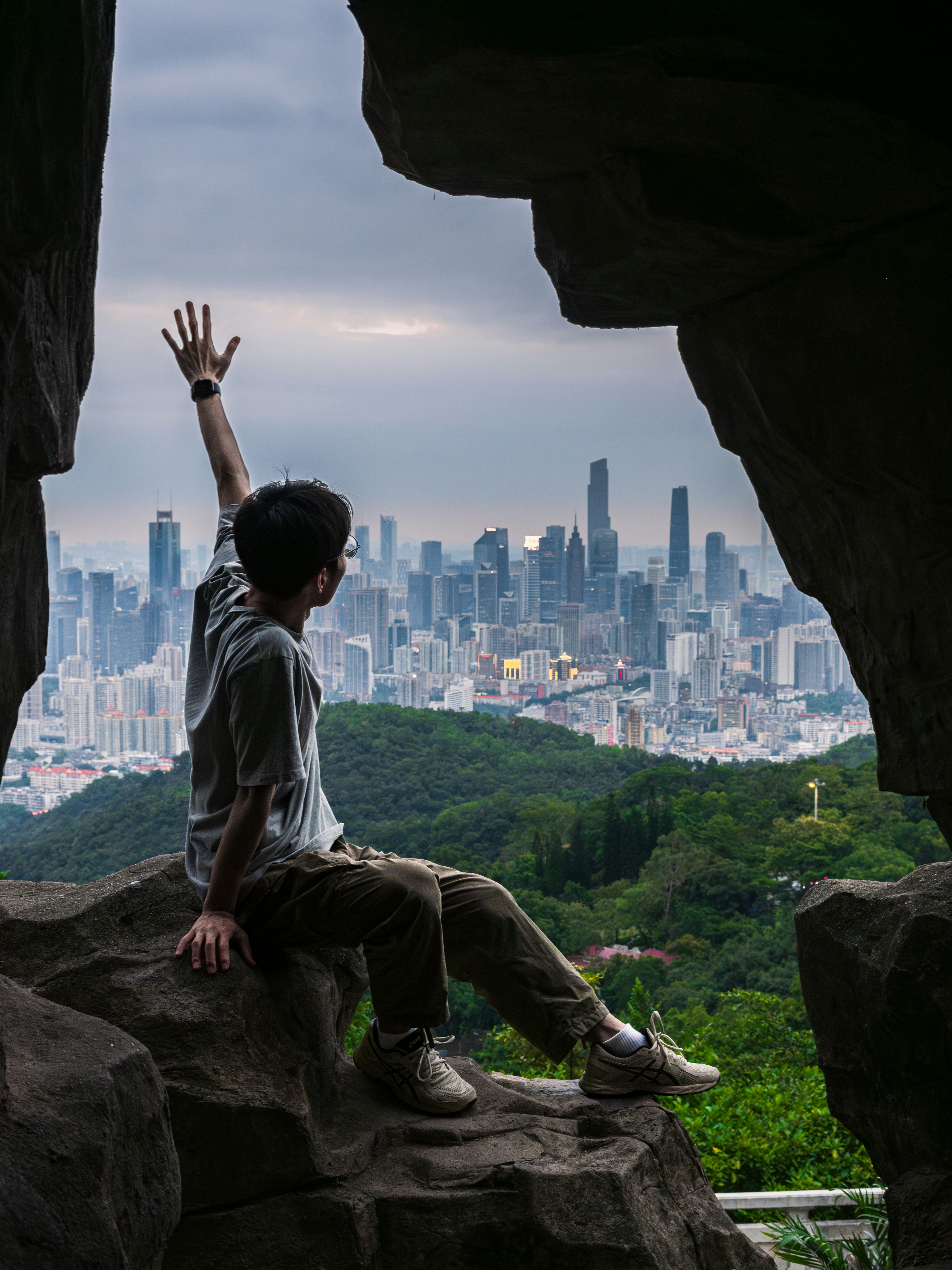Hand Raised toward the City: A Rock-Framed Overlook