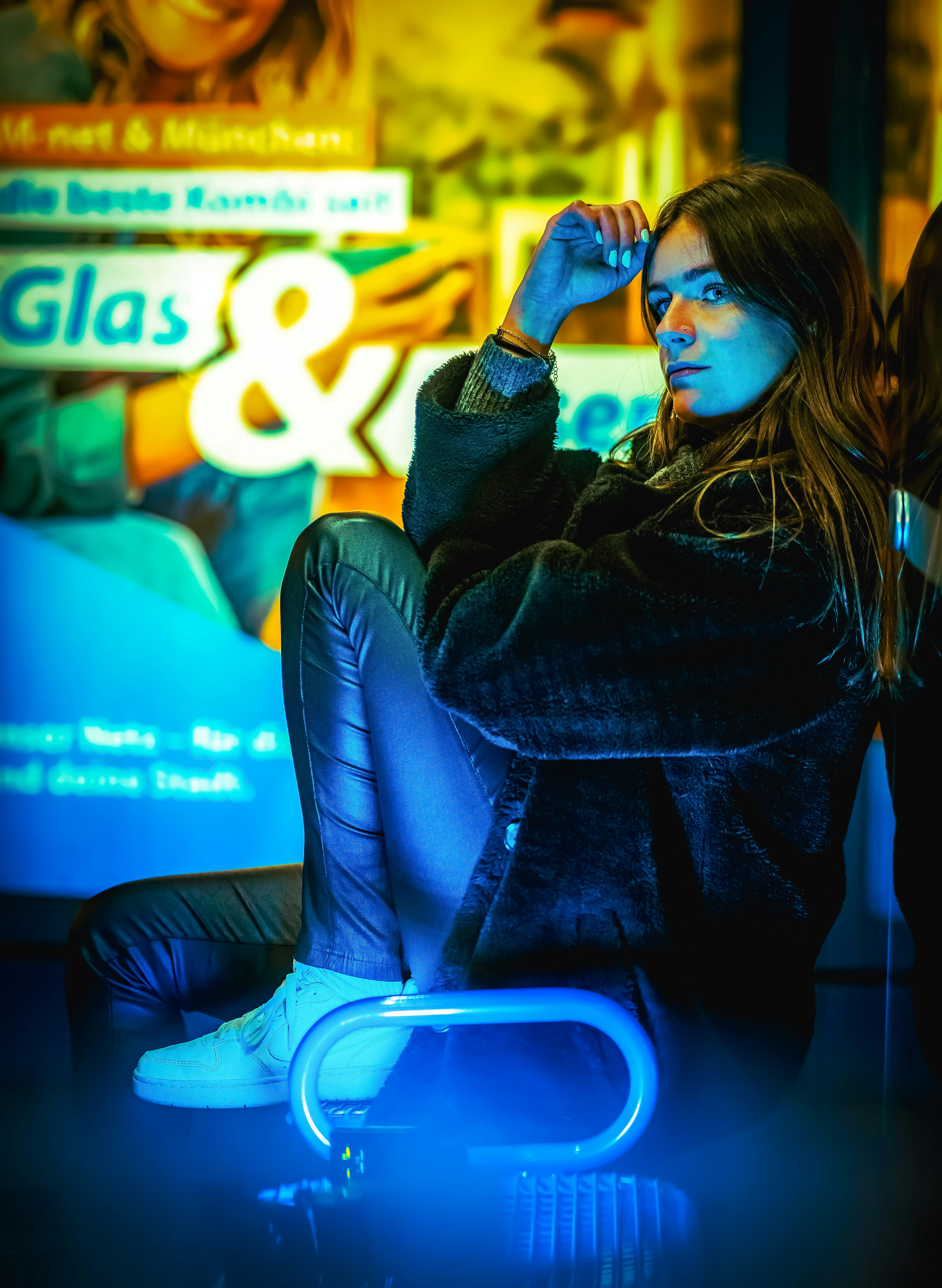 Neon Quiet: A Contemplative Moment Under Blue-Gold Signage