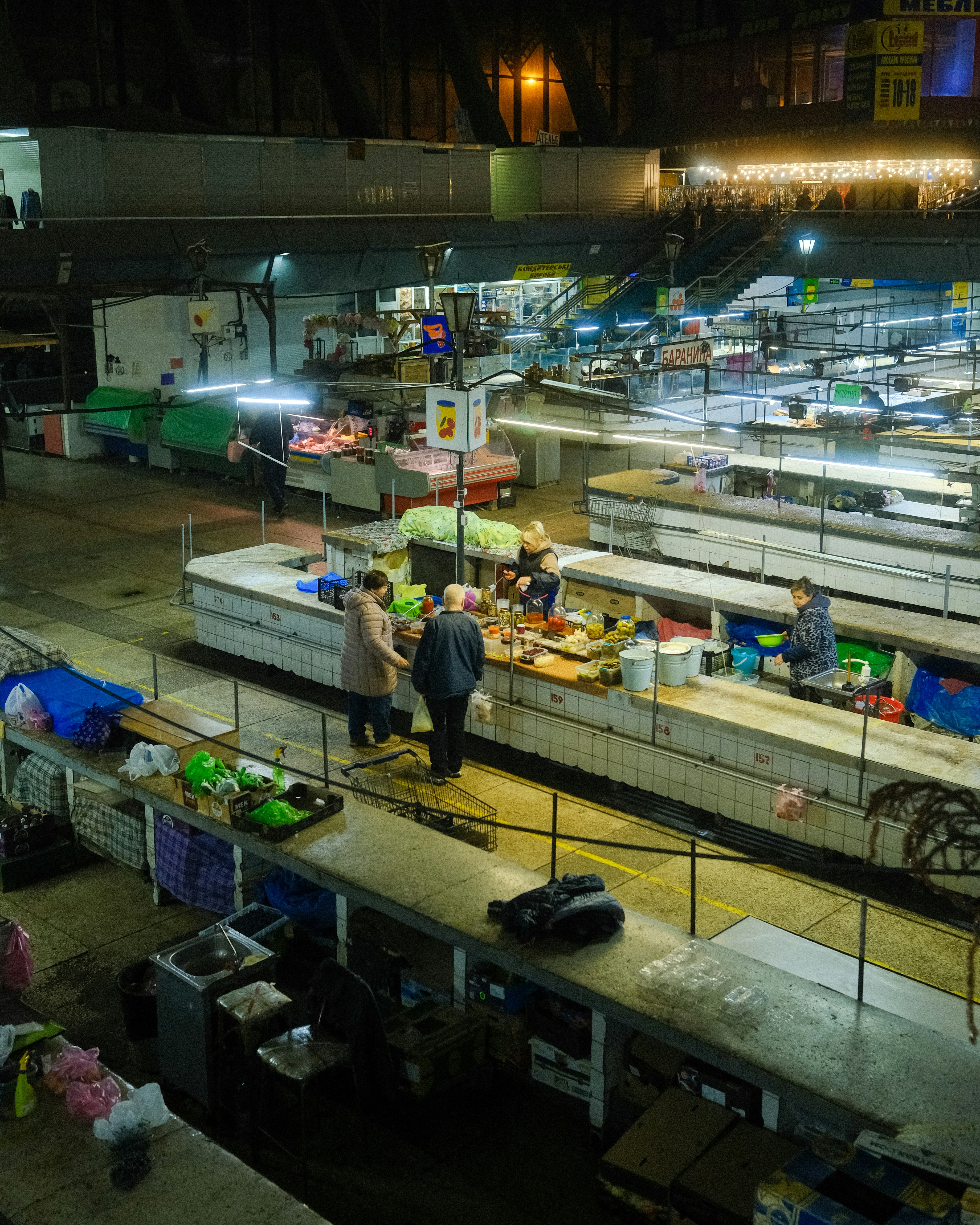 Neon Aisle at Night: Vendors Bargain Under Fluorescent Glow