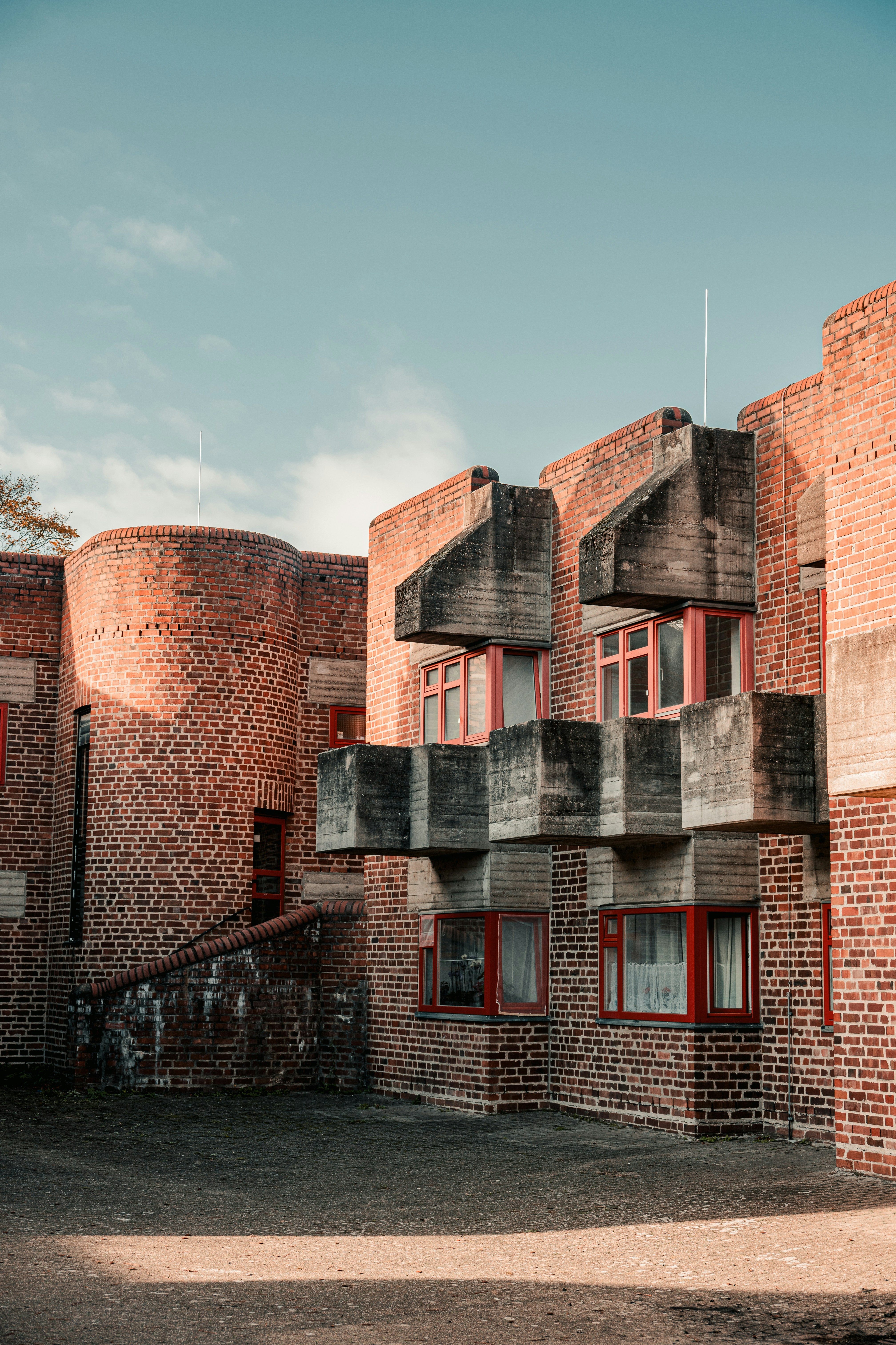 Cantilevered Concrete Boxes Over Red Brick Facade