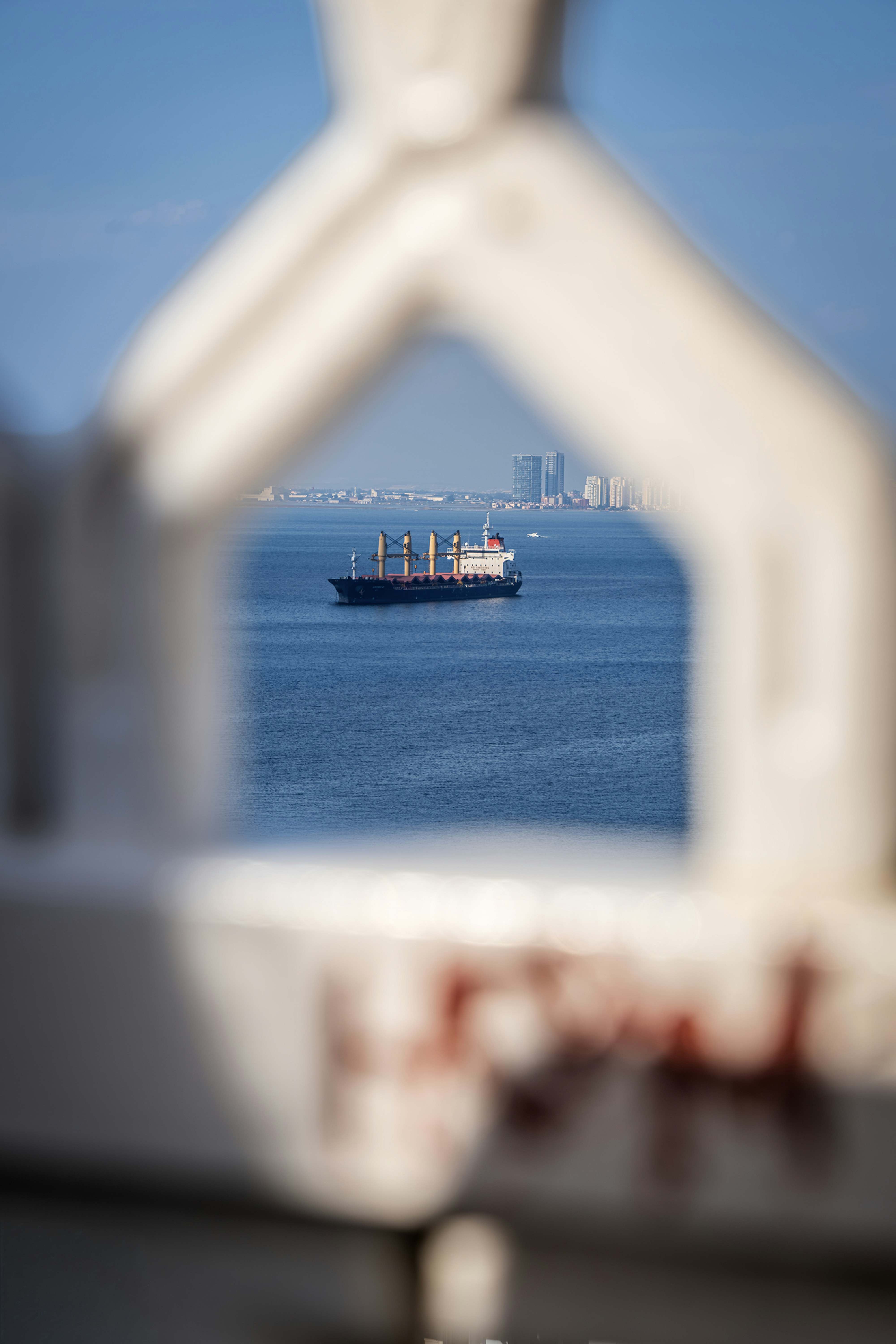Sea Gate: Cargo Vessel Framed by a Seaside Arch