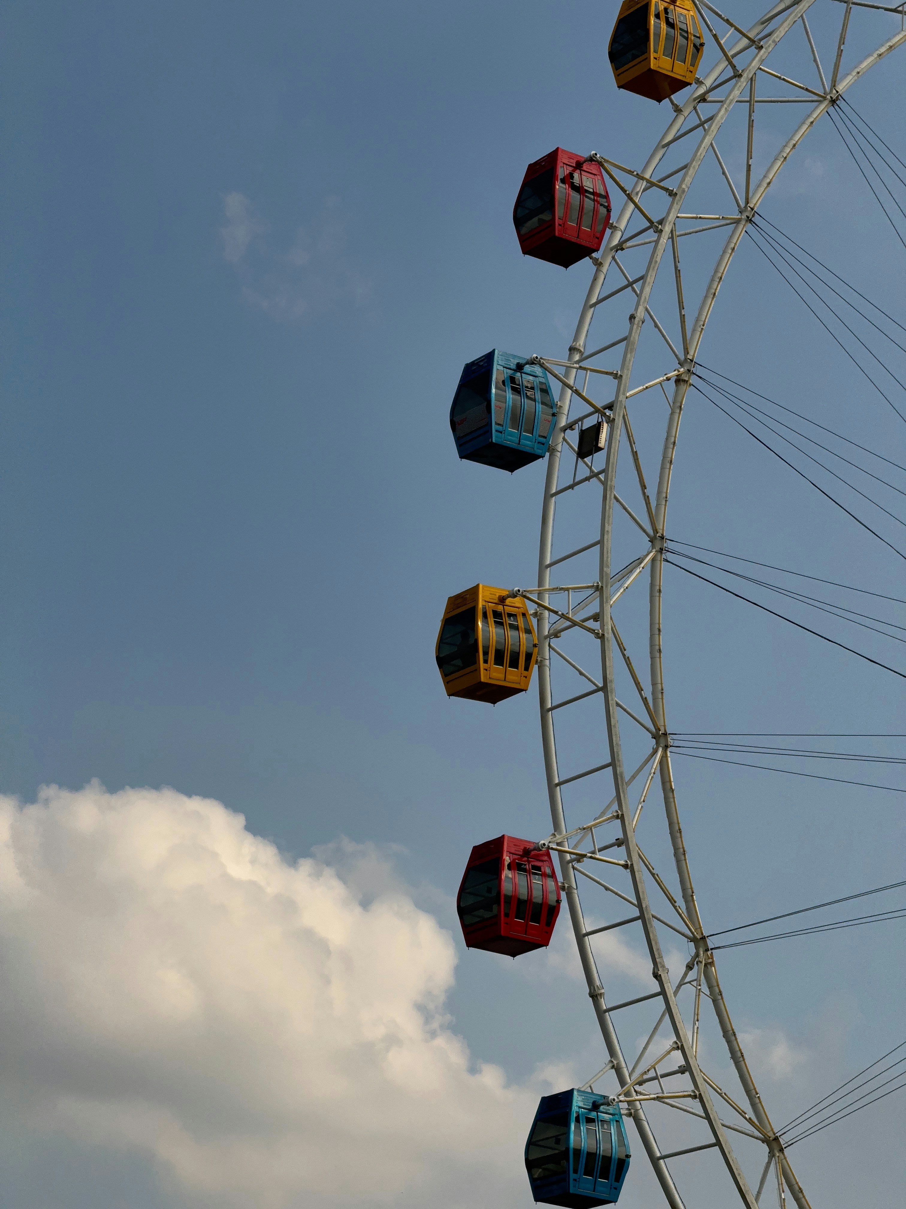 Neon Gondolas on a Sky-Blue Arc: A Ferris Wheel Snapshot