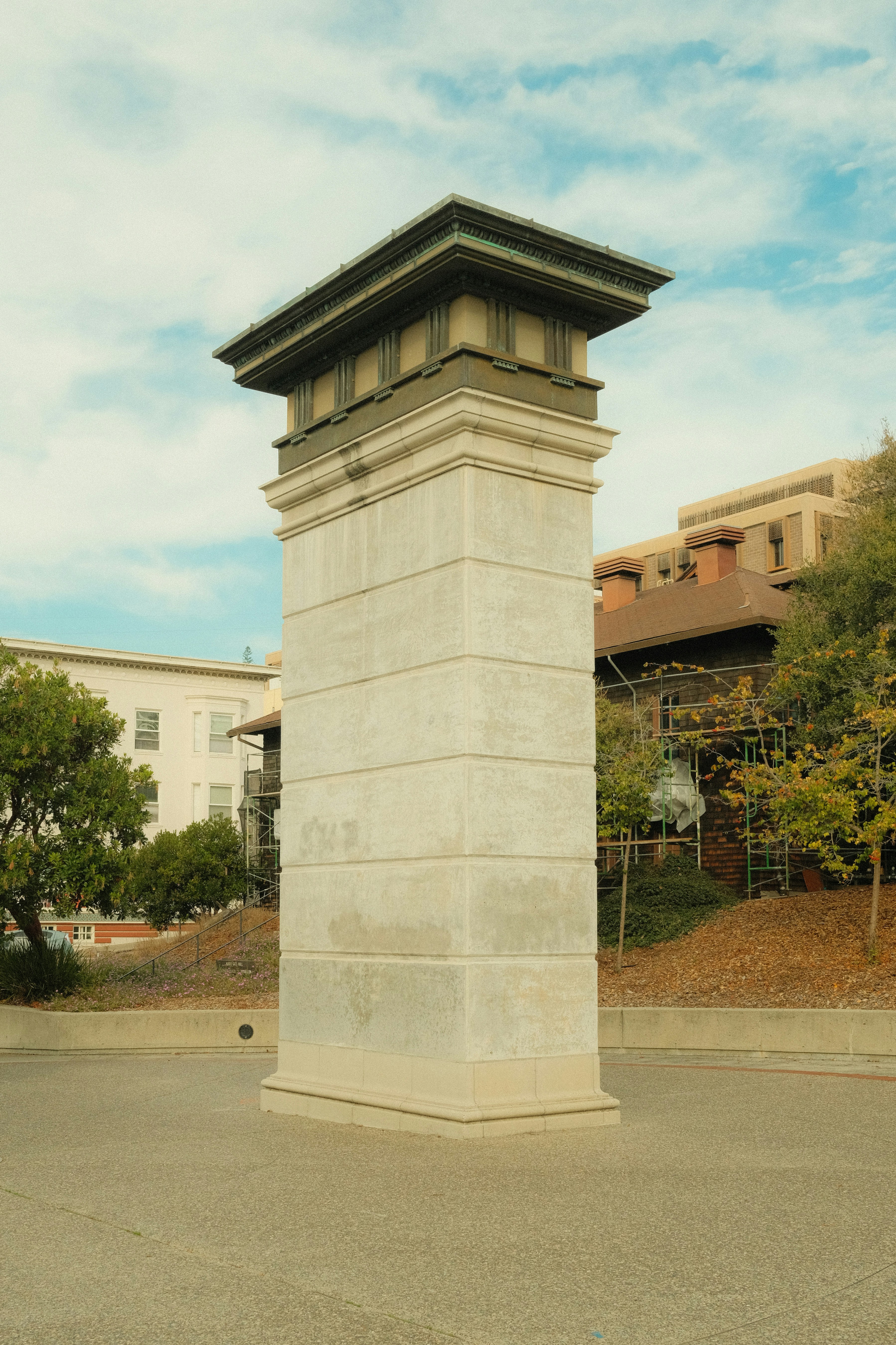 Crowned Column: a sunlit campus monument beneath a clear sky