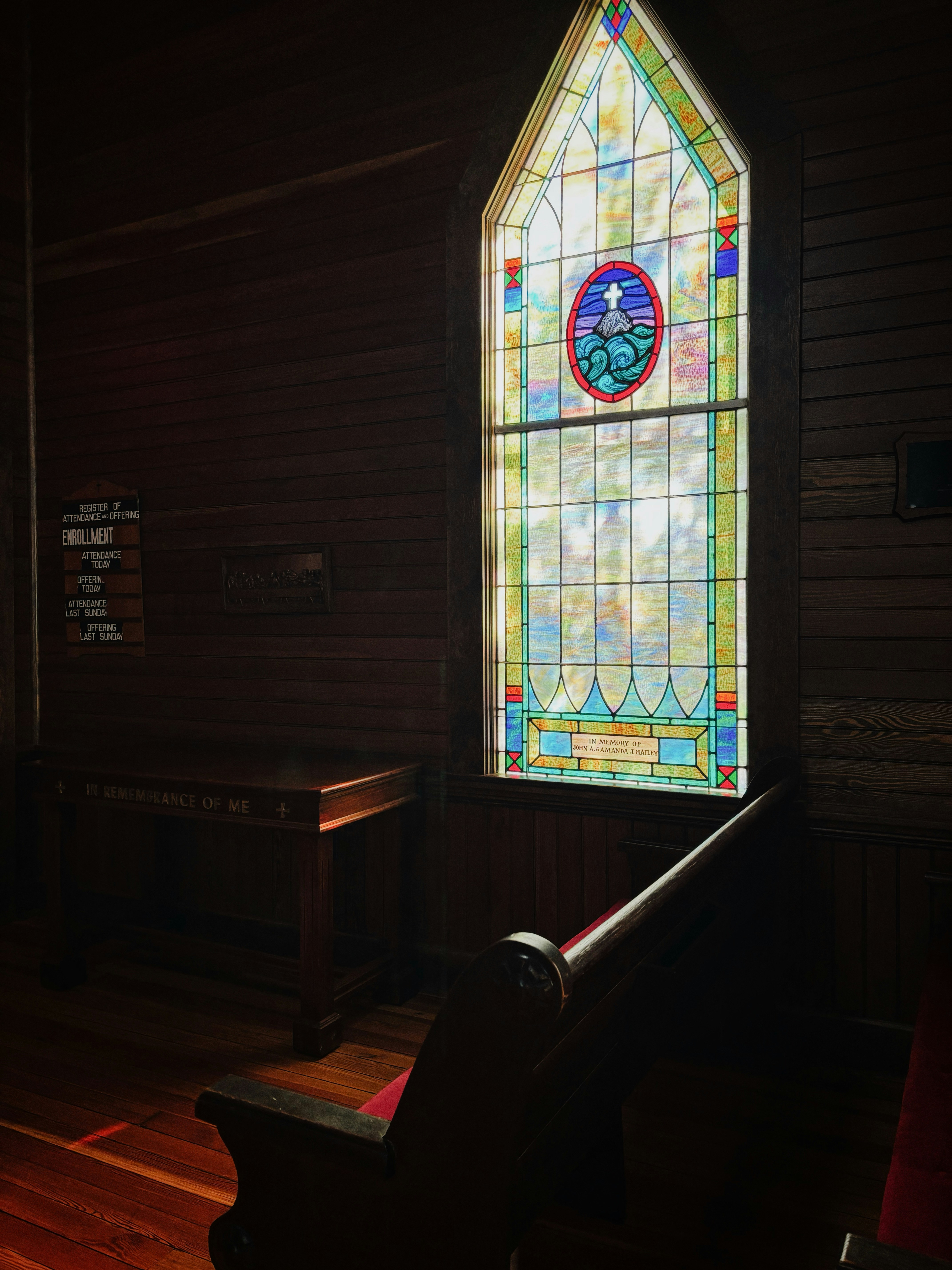Prismatic Vigil: Light Through a Stained-Glass Window in a Dim Chapel