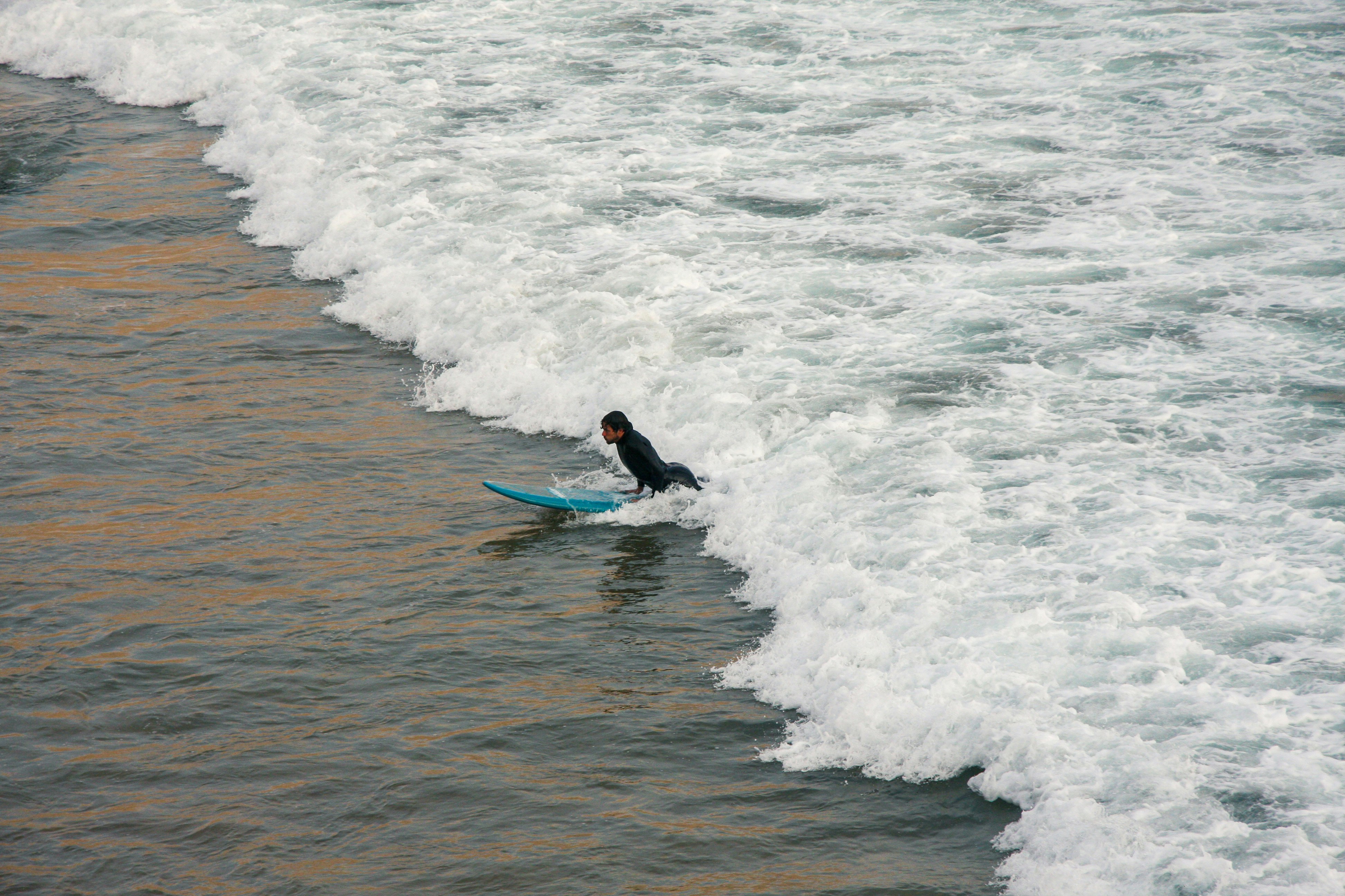 Surfer trying to catch a wave in Imsouane, Morocco