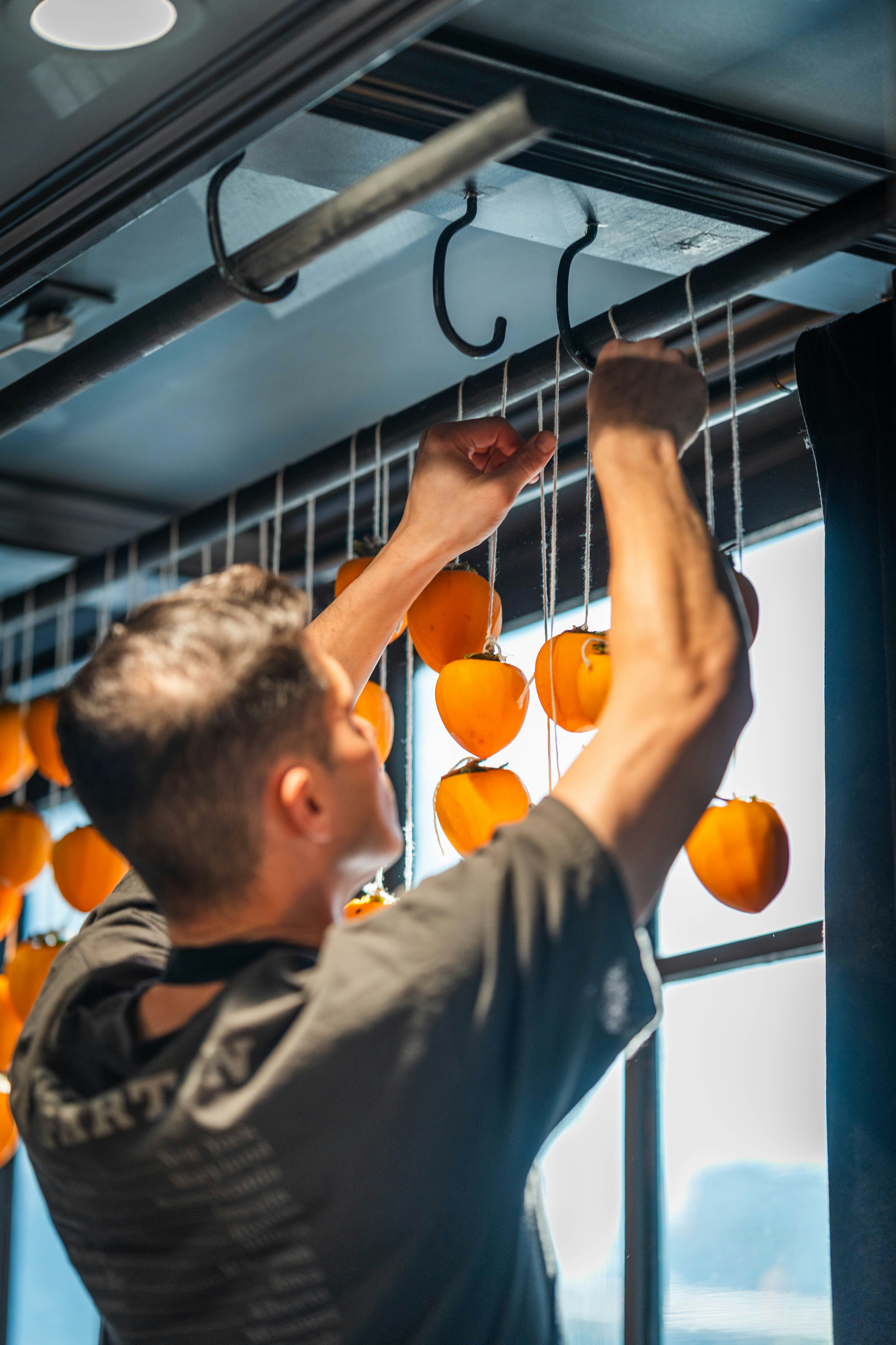 Hands in Motion: Stringing Dried Persimmons into a Sunlit Garland