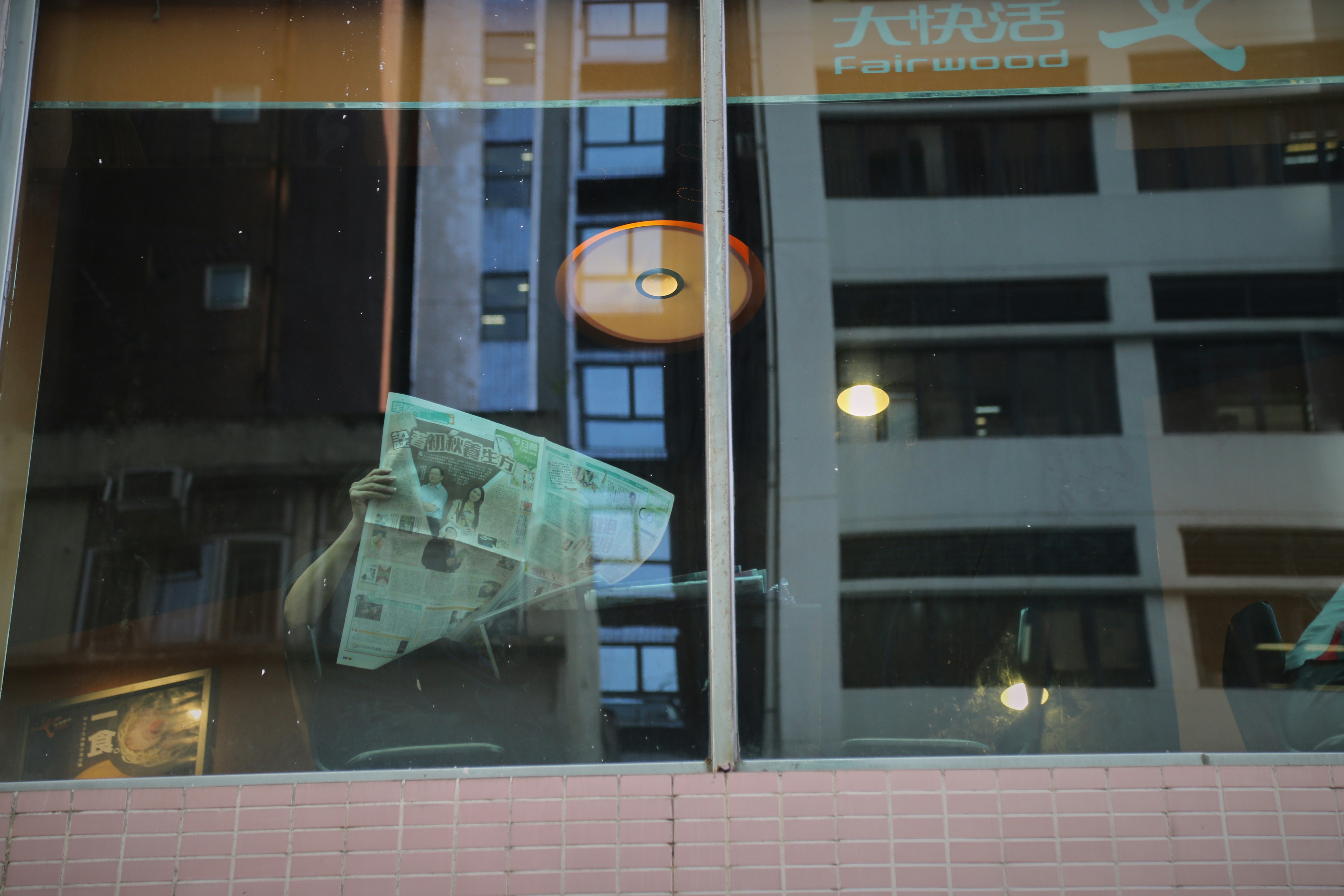 Pane Witness: A Quiet City Moment with a Folded Newspaper