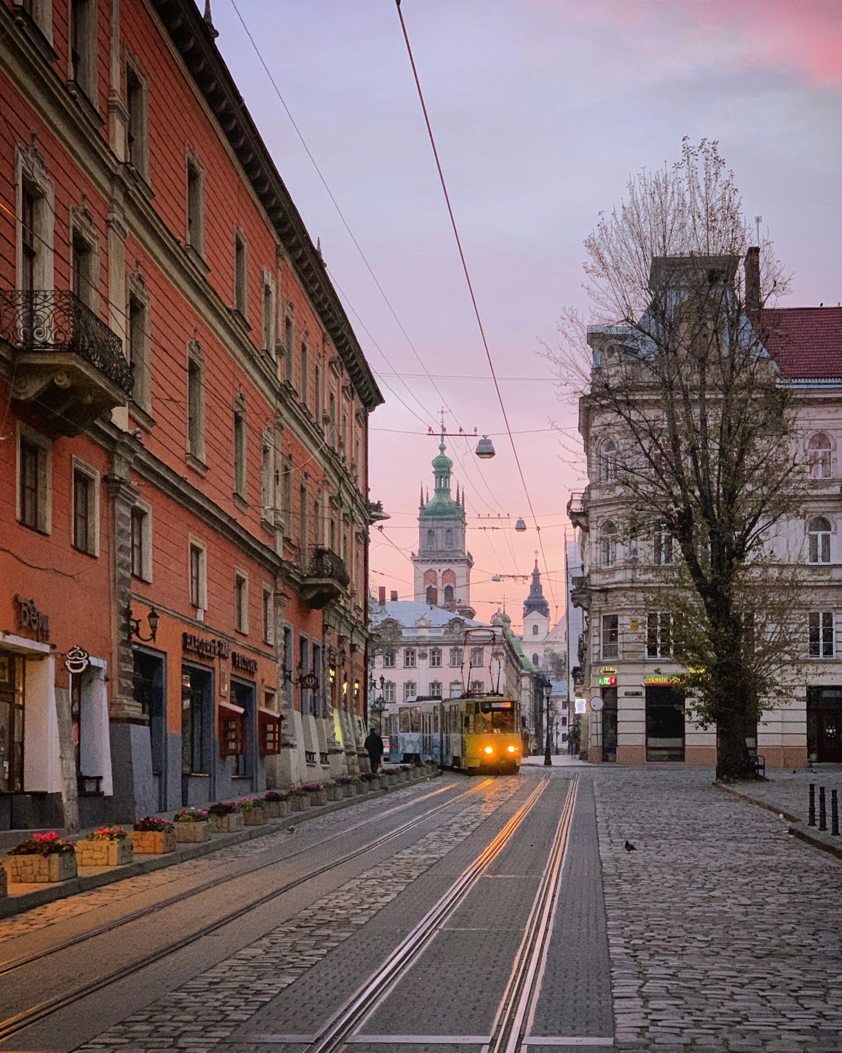 Late autumn dawn over a historic city street with a tram in Lviv, Ukraine, November 2019