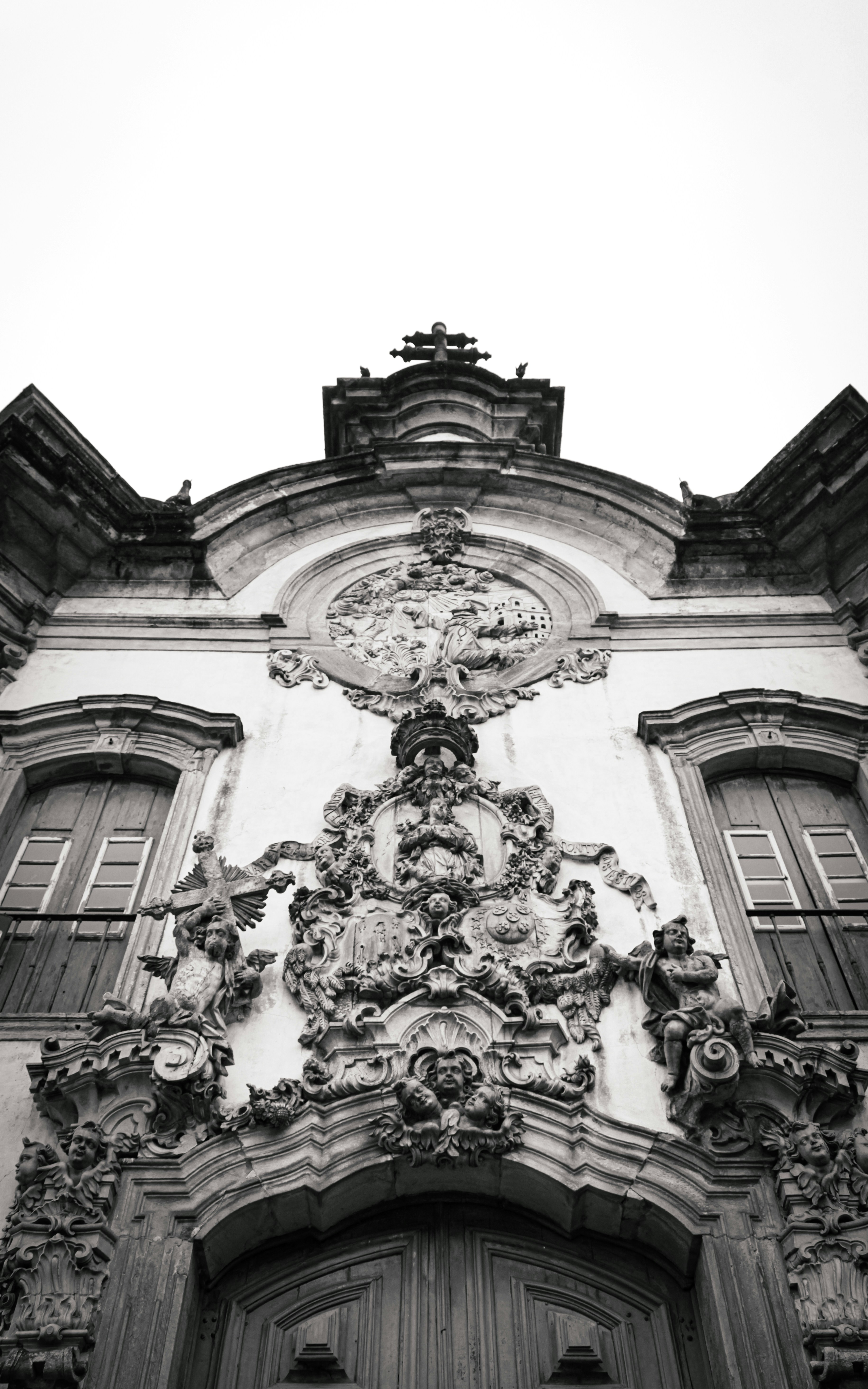 Monochrome Baroque Crest: Central Façade Sculpture Rising Above the Door