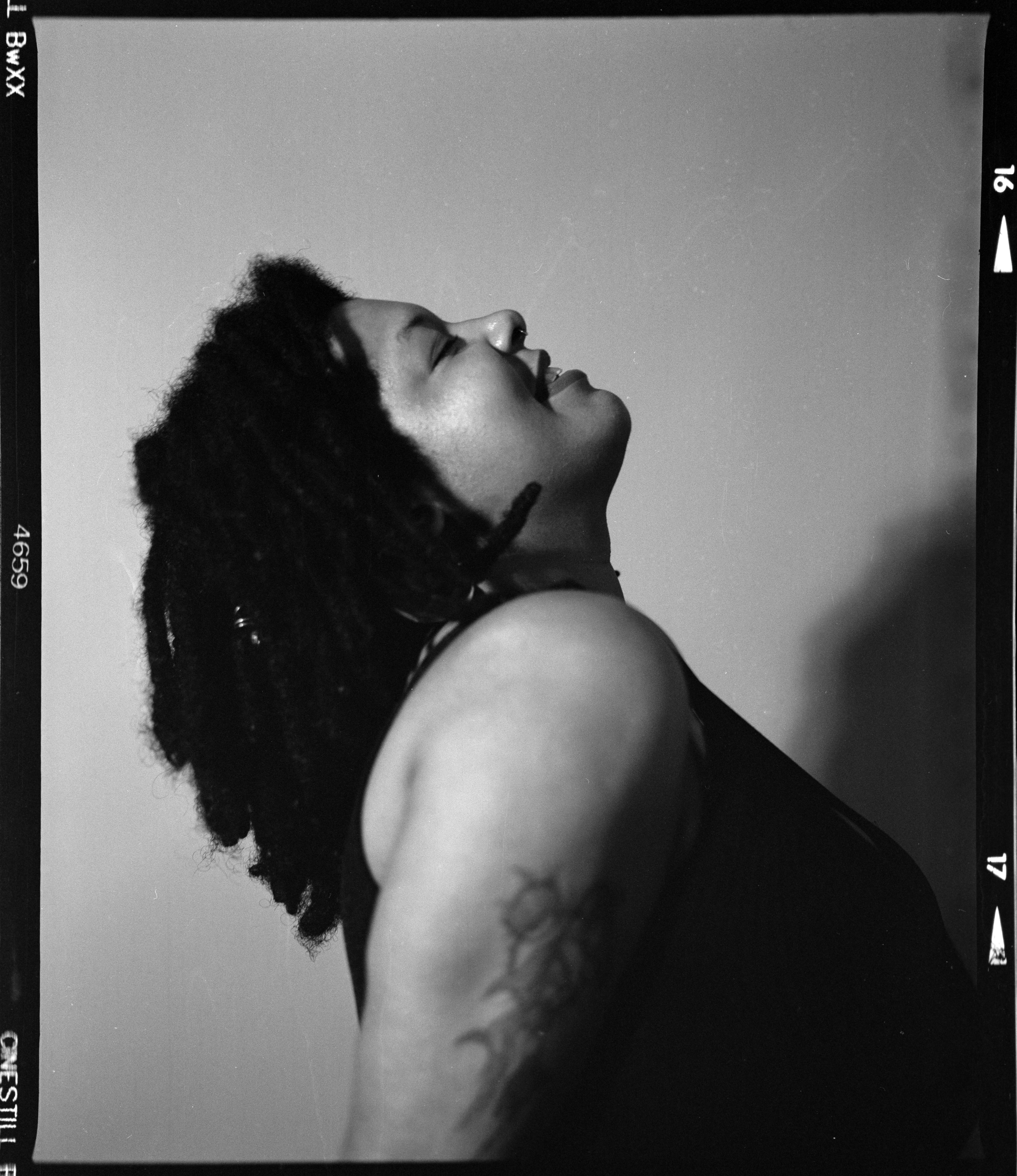 Tilted Grace: A Dreadlocked Portrait in Quiet Monochrome