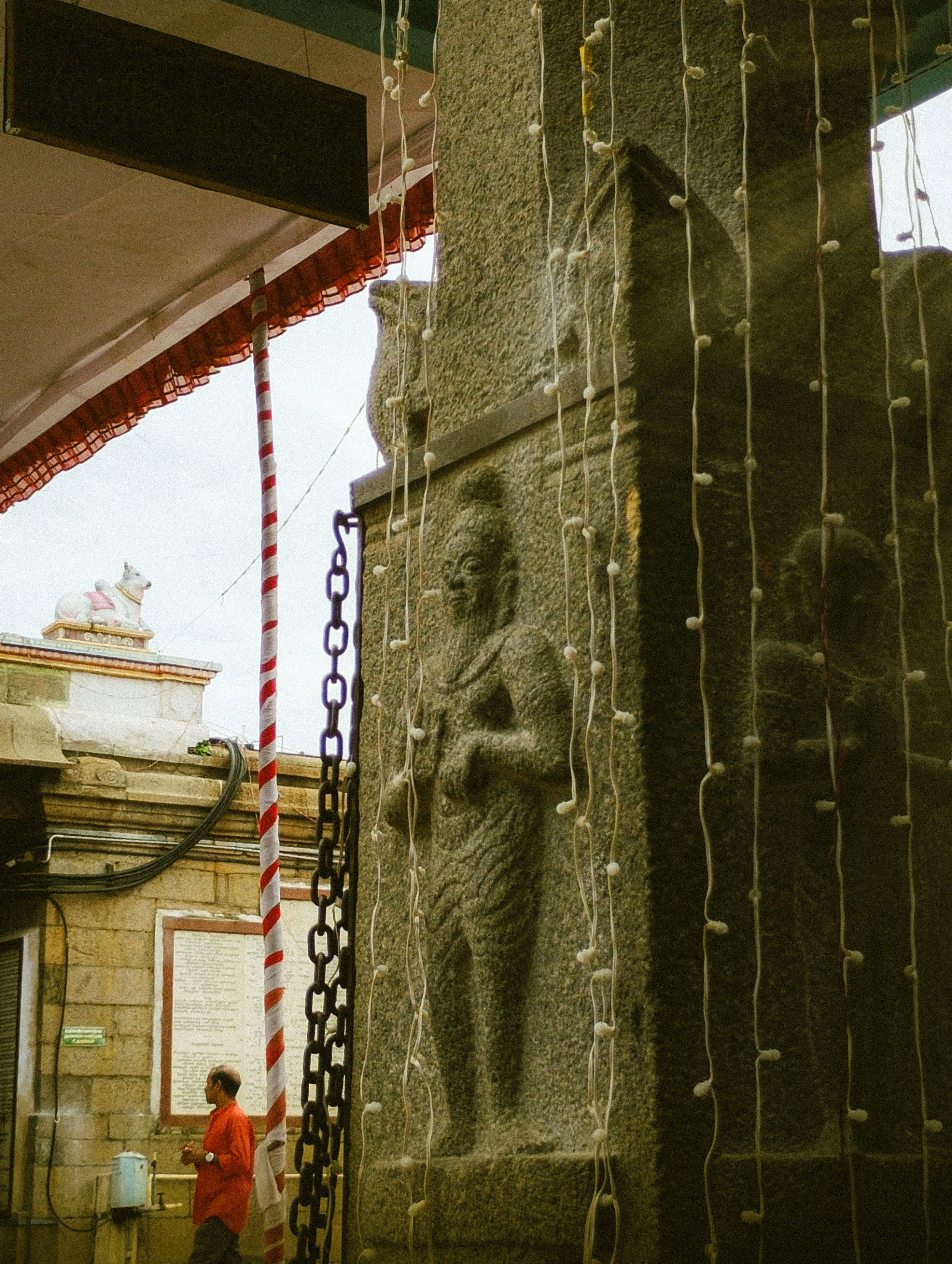 Stone carving of a deity on a pillar with lights