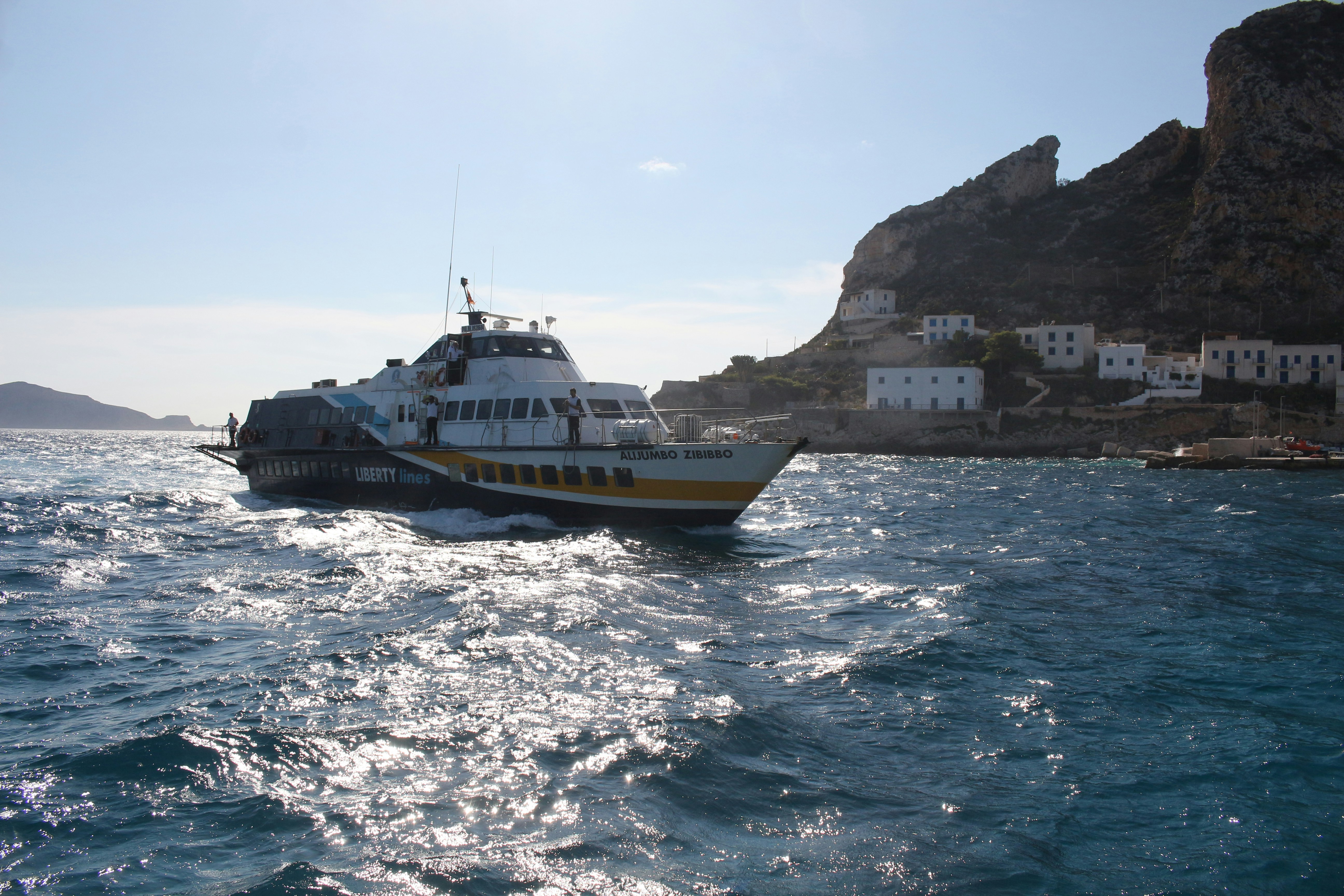 Sunlit Ferry Cutting Through a Glinting Coastal Channel