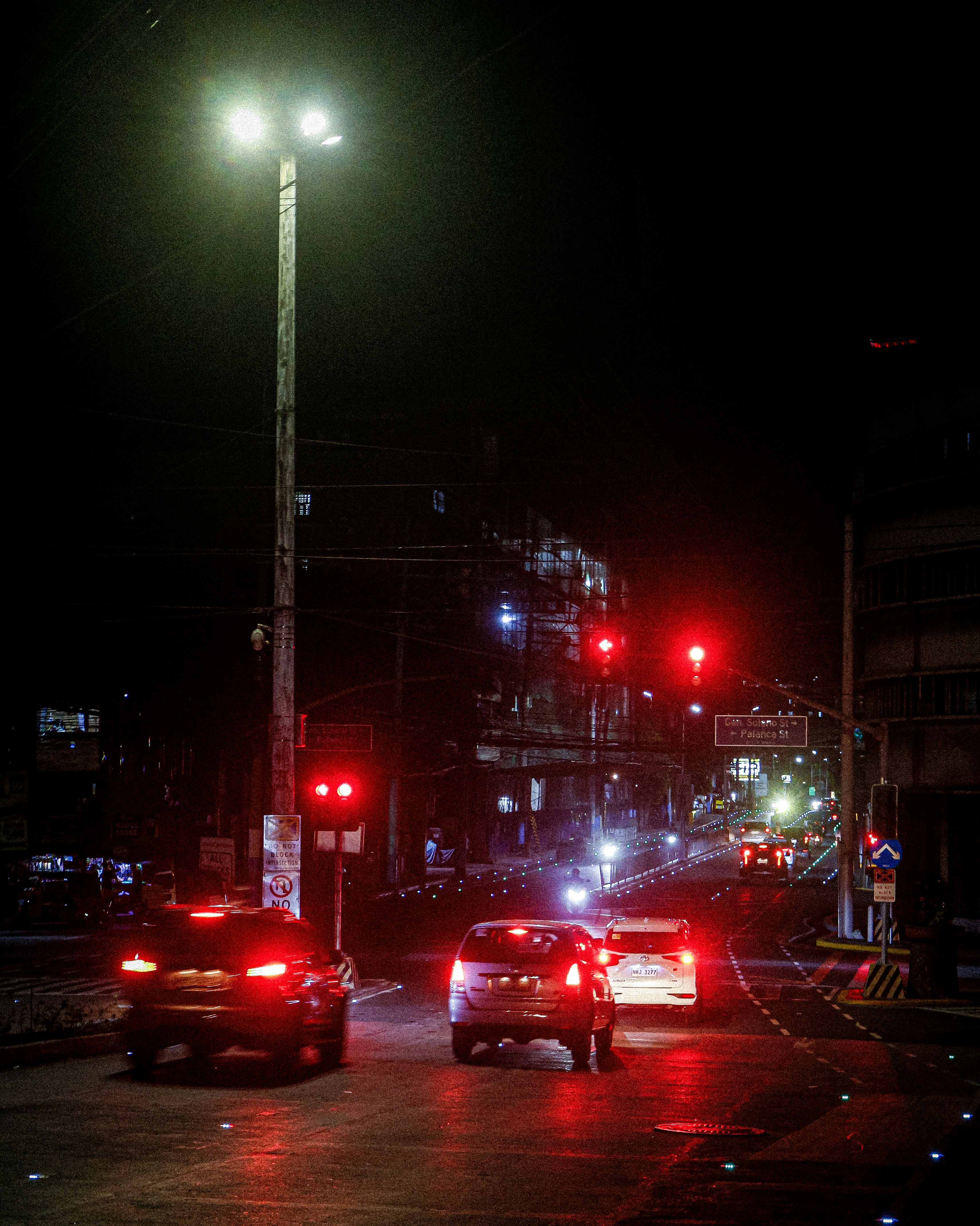 Midnight Red: Tail Lights Guiding a Quiet Downtown Intersection