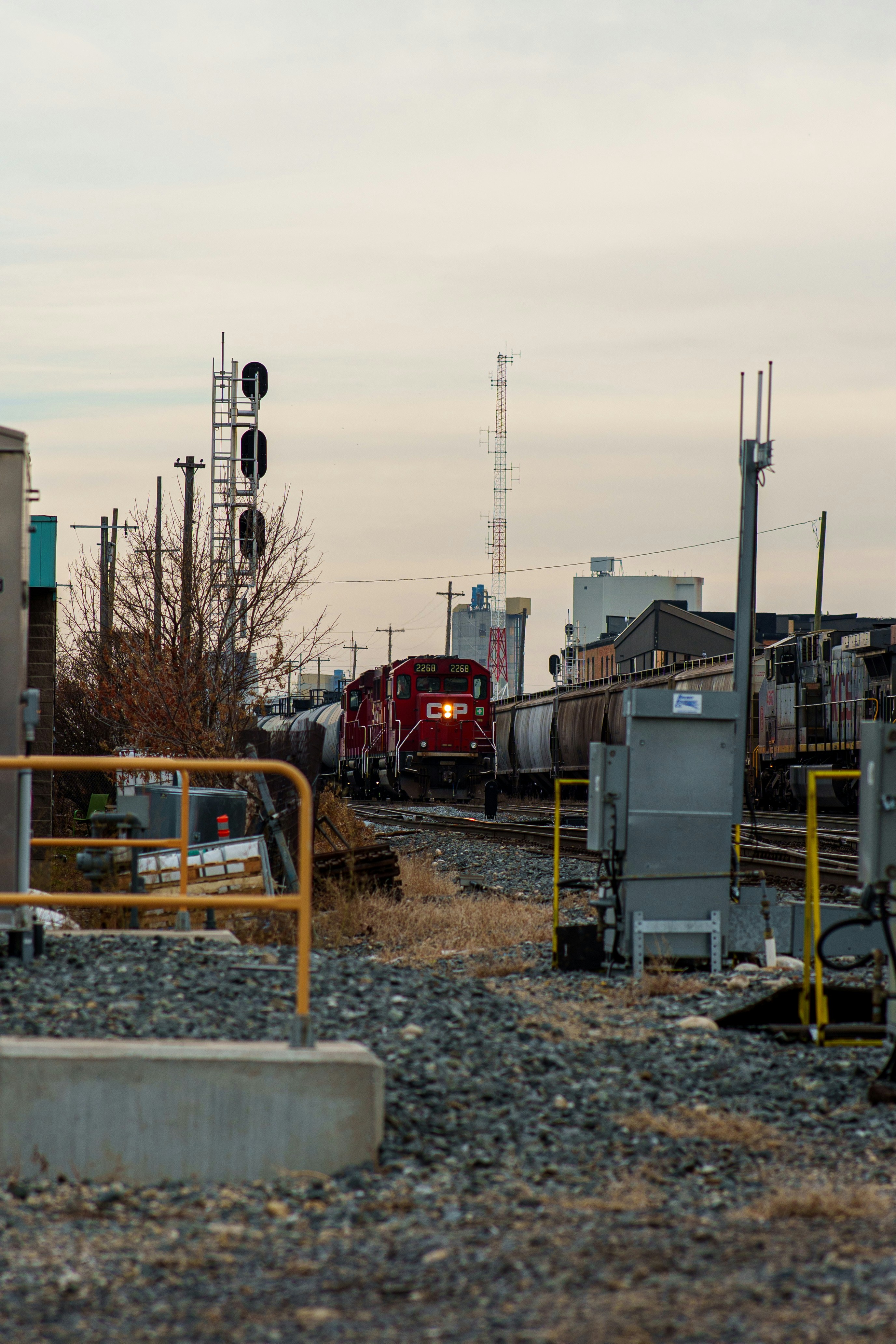 Red locomotive anchors a quiet rail yard at dusk